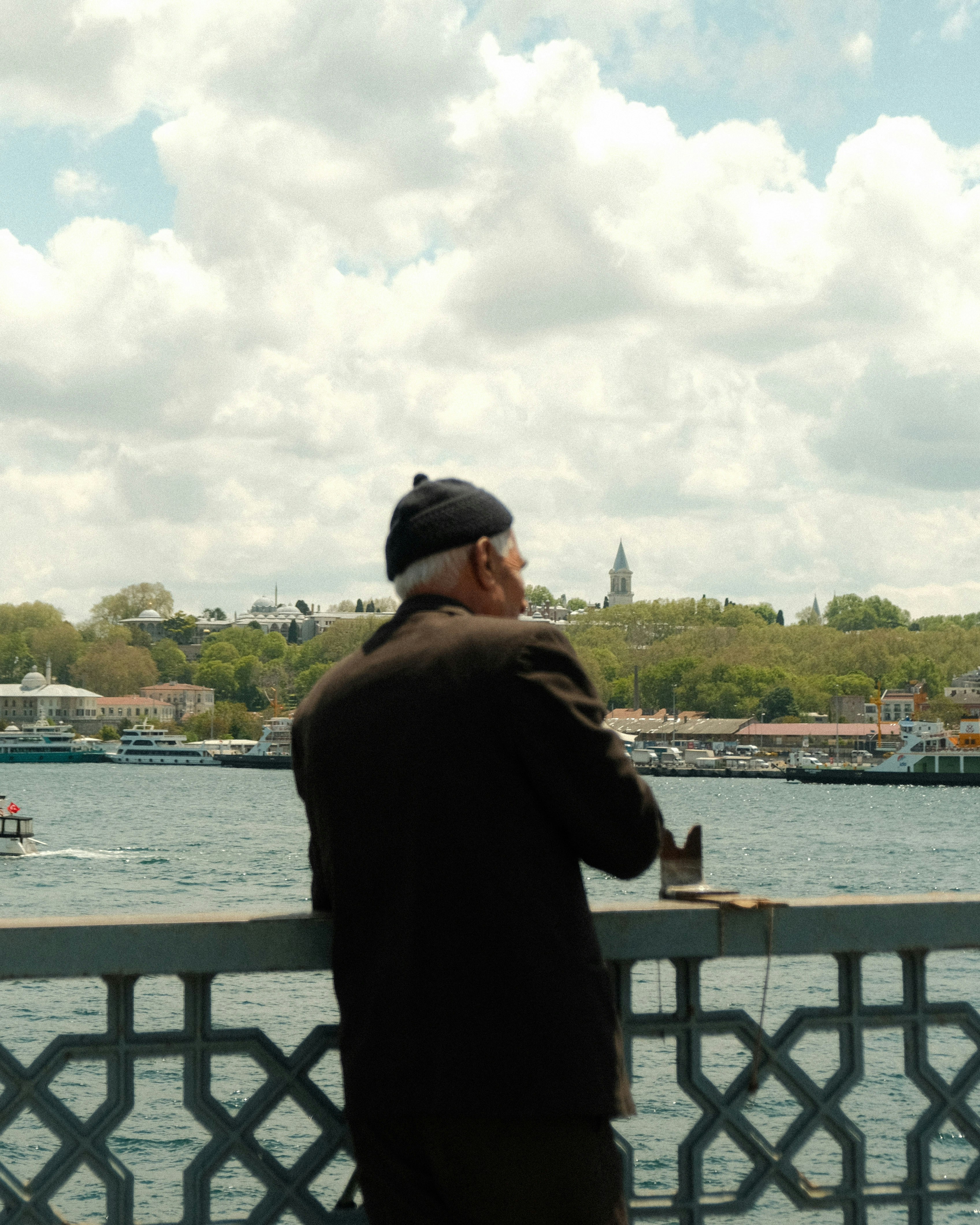 Silhouette at the Waterfront: A Reflective Moment Over the Railing