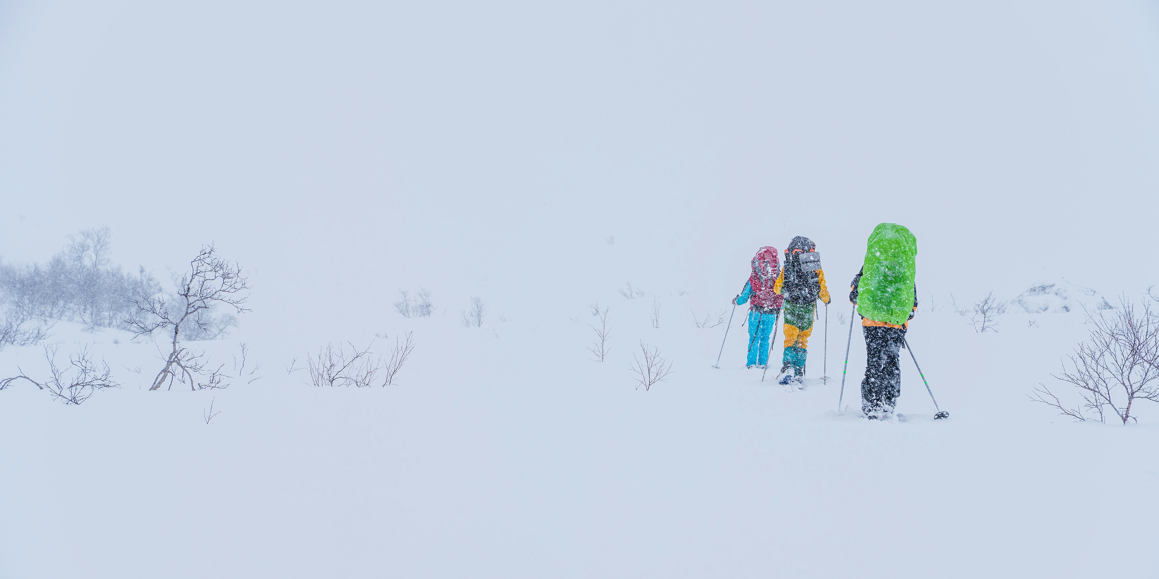 People hike in snowy conditions.