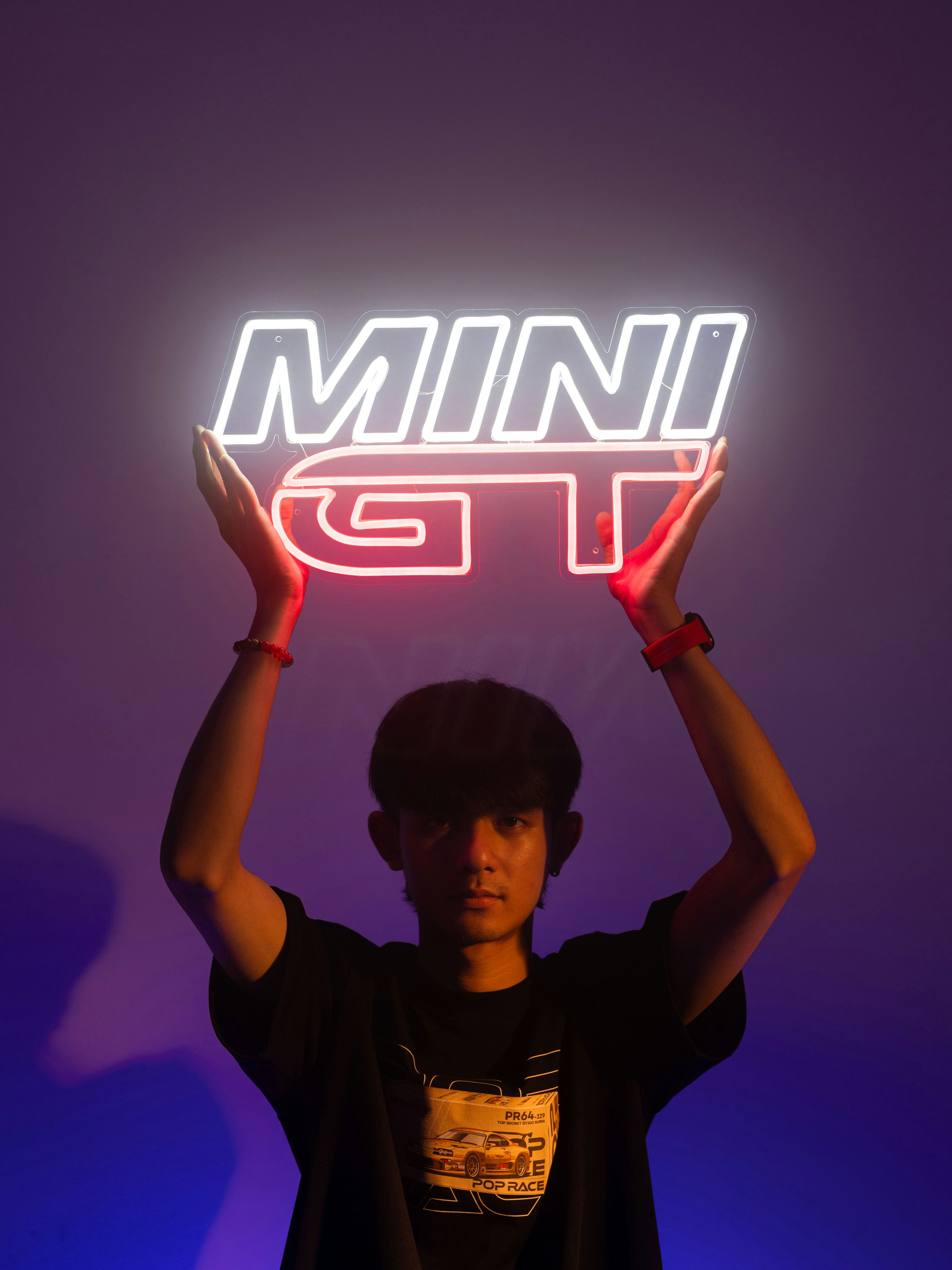 Person holding a neon "mini gt" sign. photo – Free Colorful Image on ...