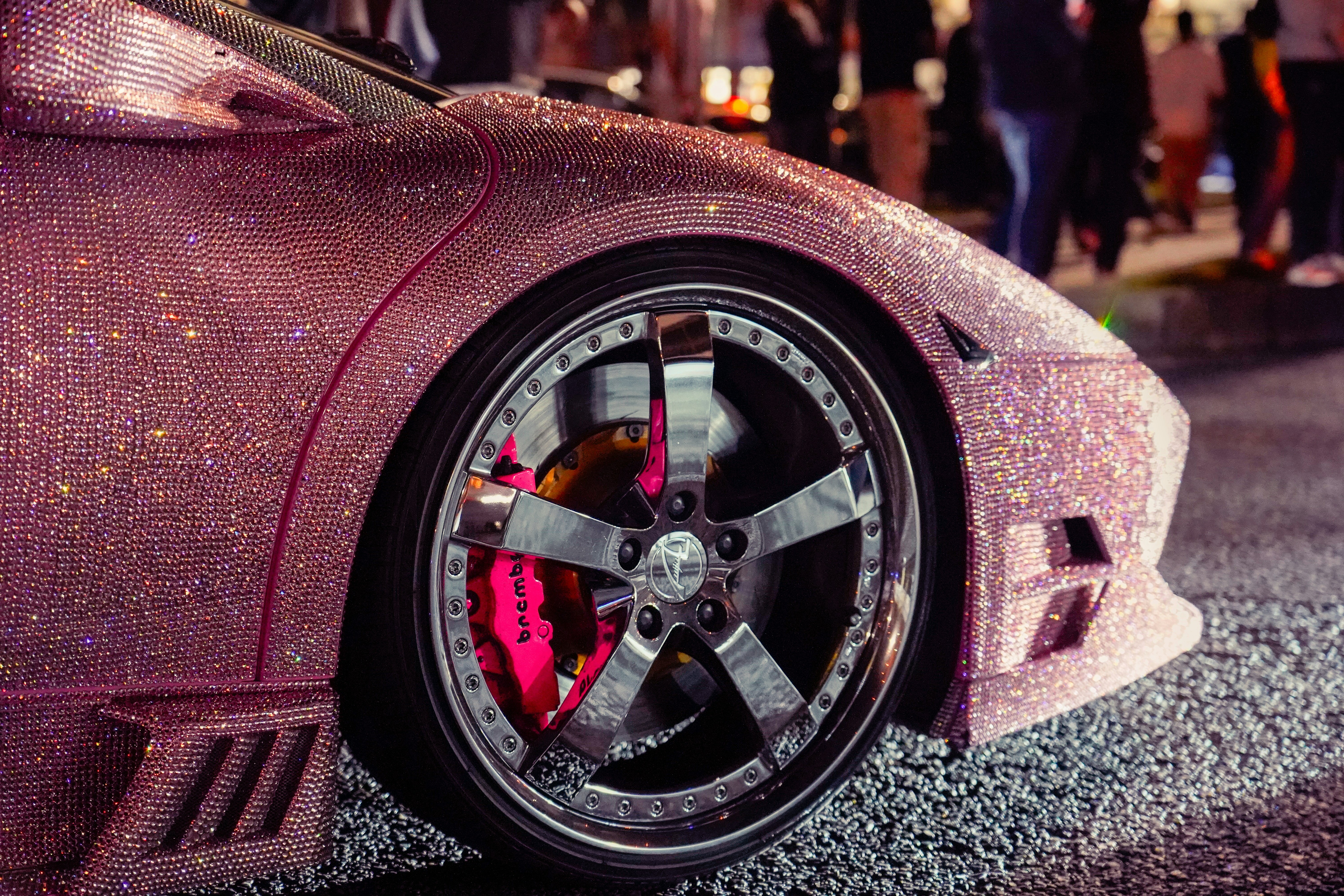 Gilded Neon Wheel: Pink Caliper and Glitter Paint Under City Lights