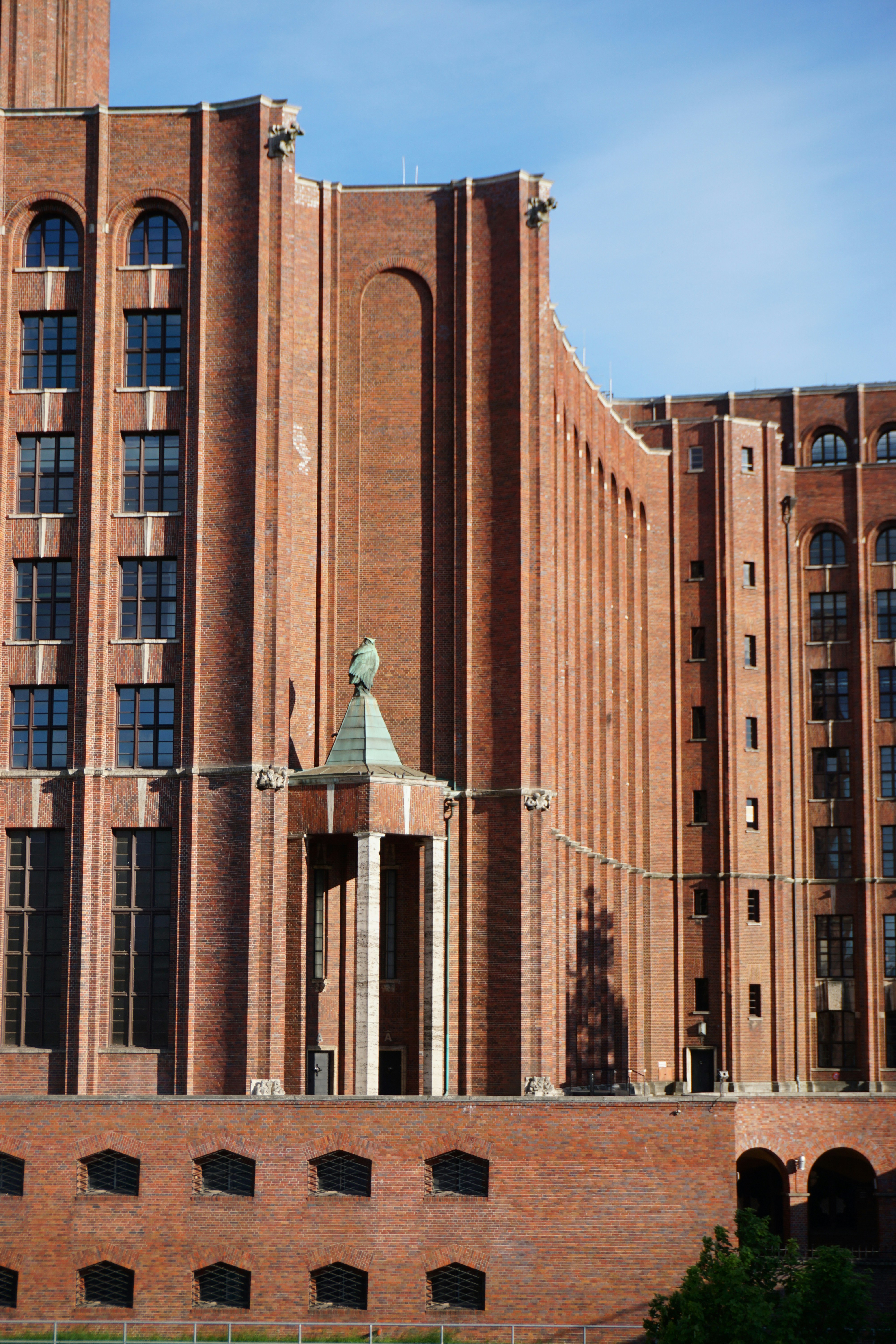 Green-Roofed Niche Among Red Brick Facades Under a Pristine Azure Sky