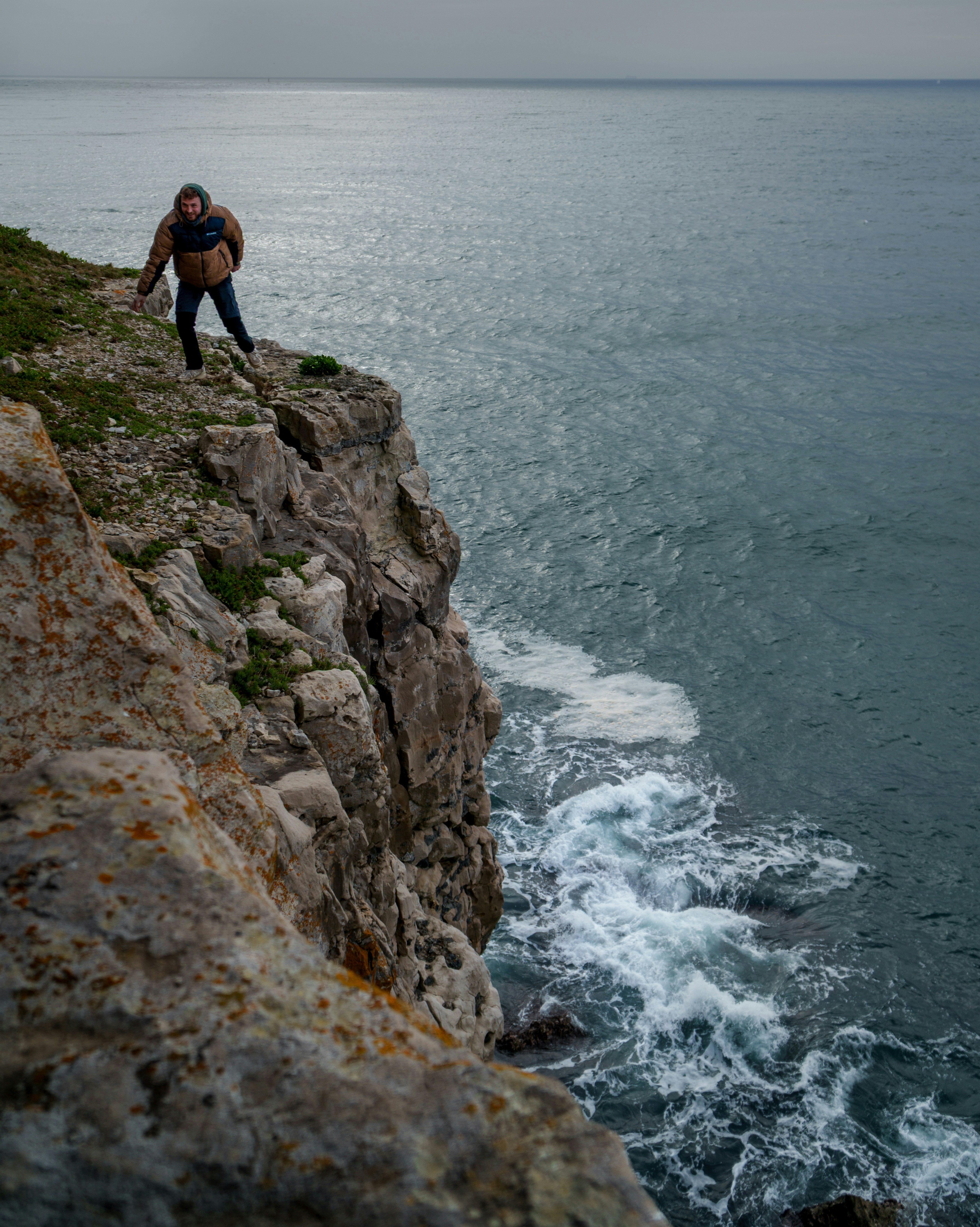 Edgewalker on a Weathered Cliff Above a Turquoise Sea
