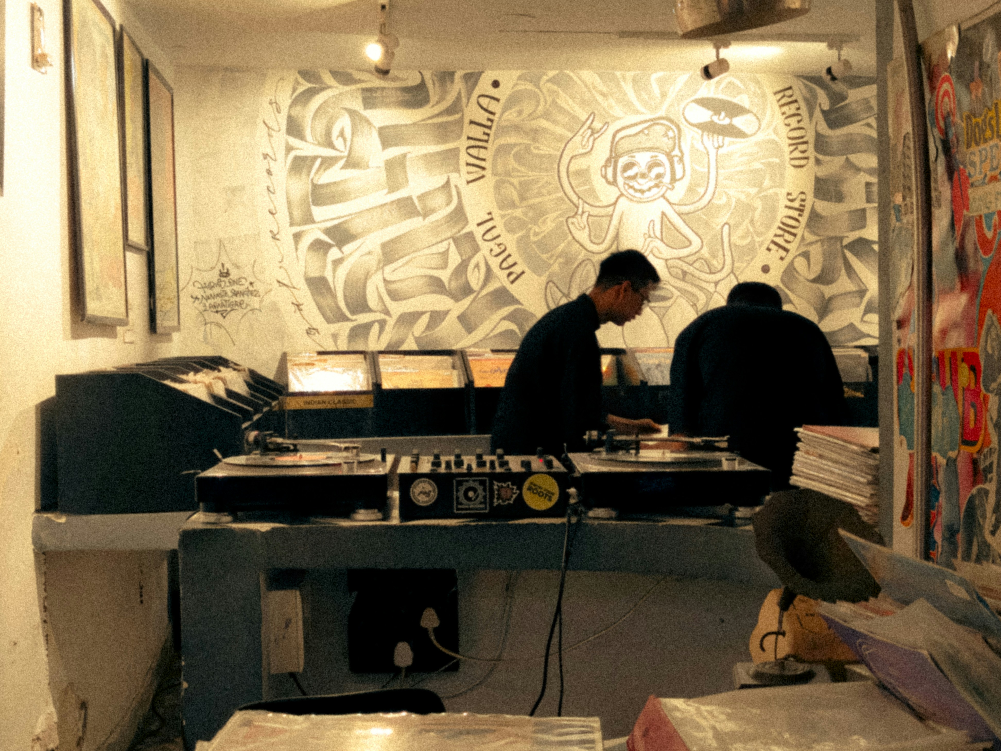 People browse records in a dimly lit shop.