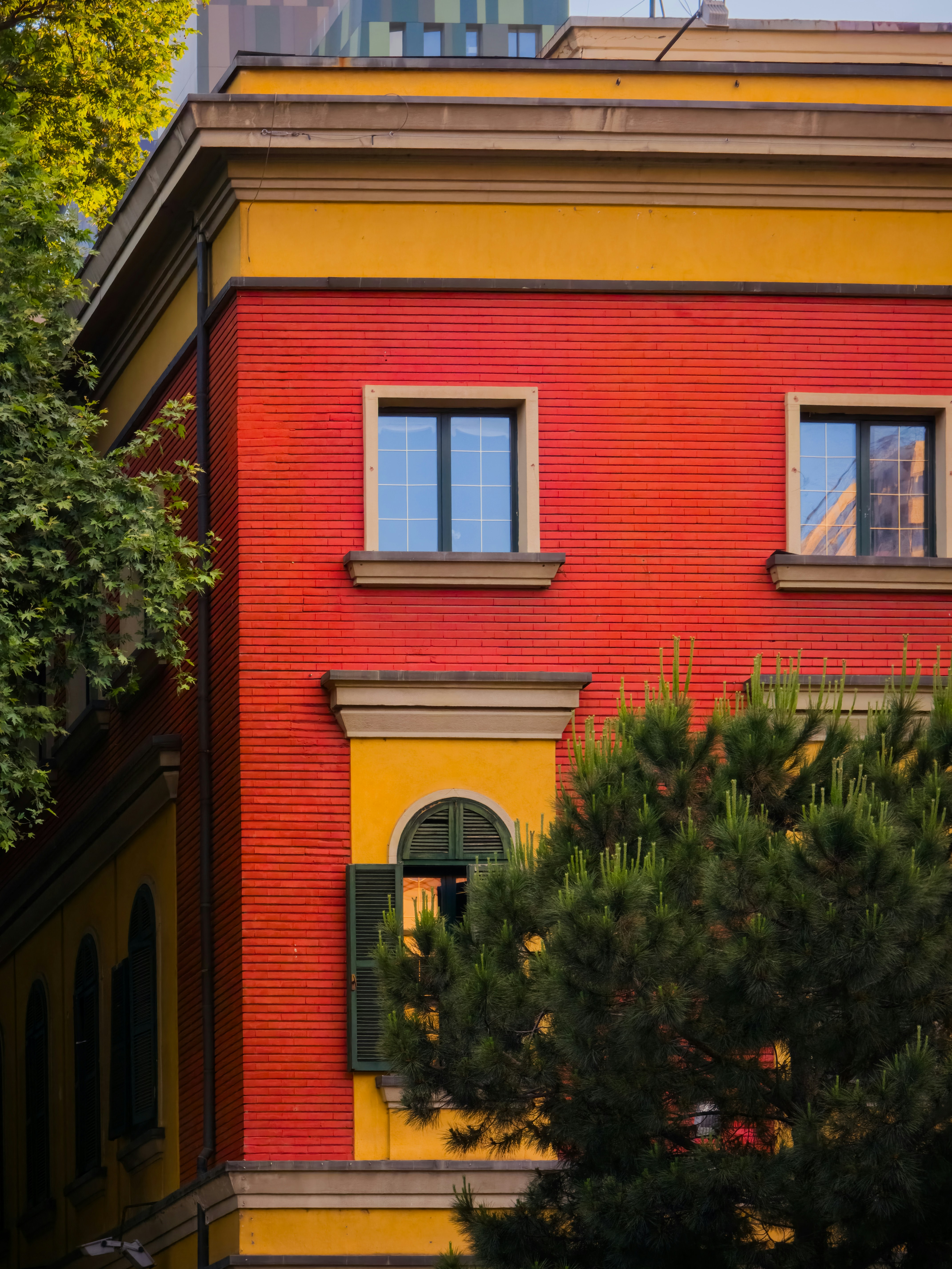A colorful building is seen amongst trees. photo – Free Wallpaper 4k ...