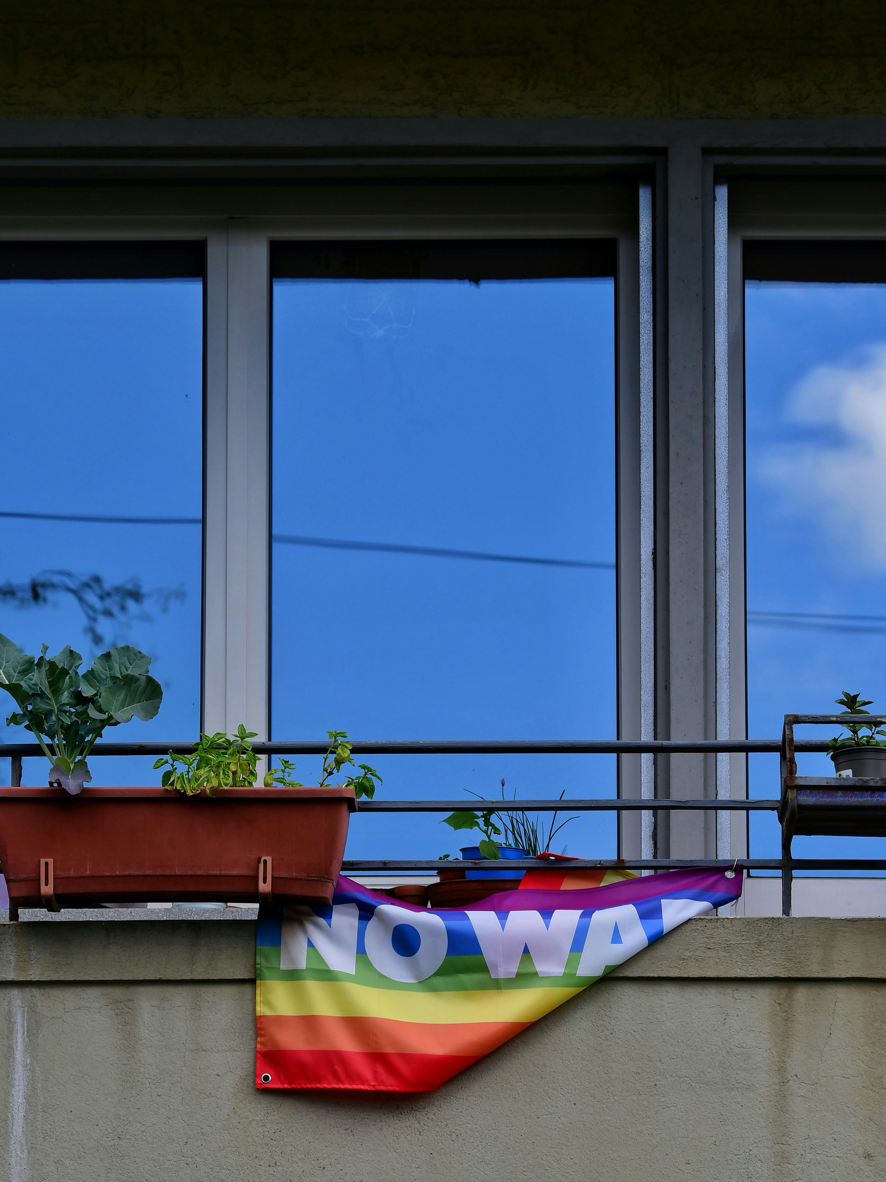 No War Banner Draped Over a City Balcony Beneath Azure Glass