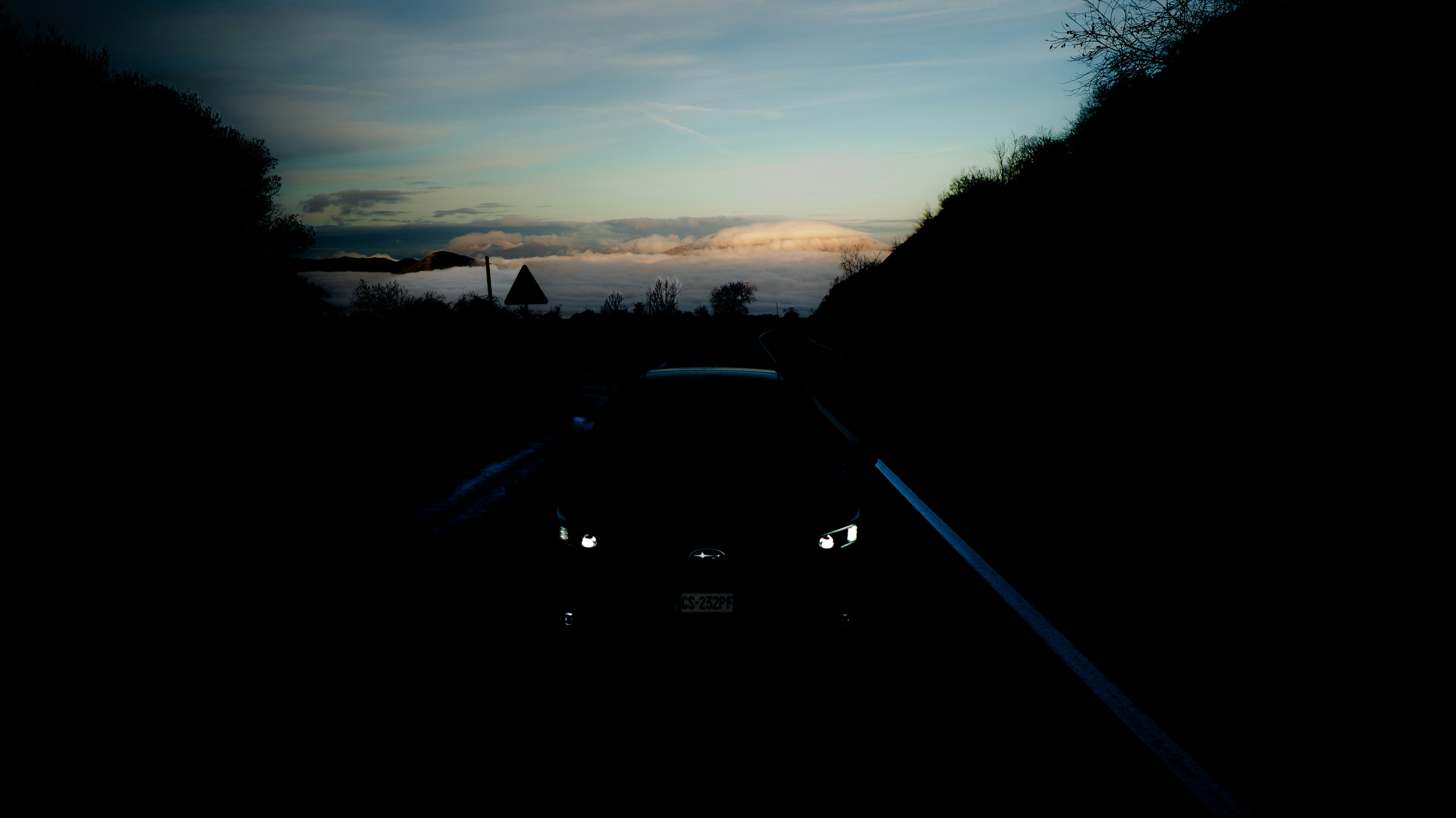 A car drives down a dark road.