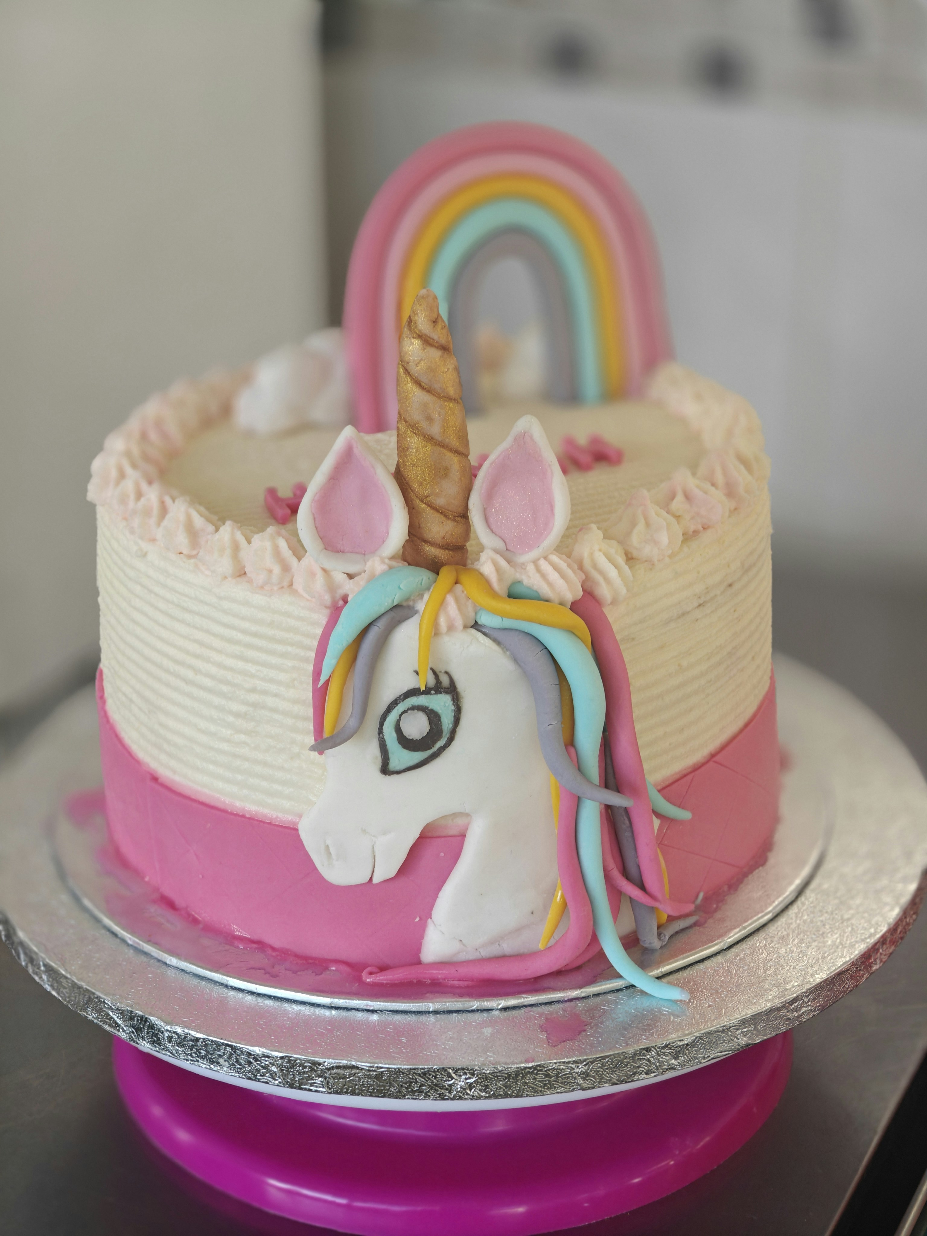 A unicorn cake with a rainbow on top.