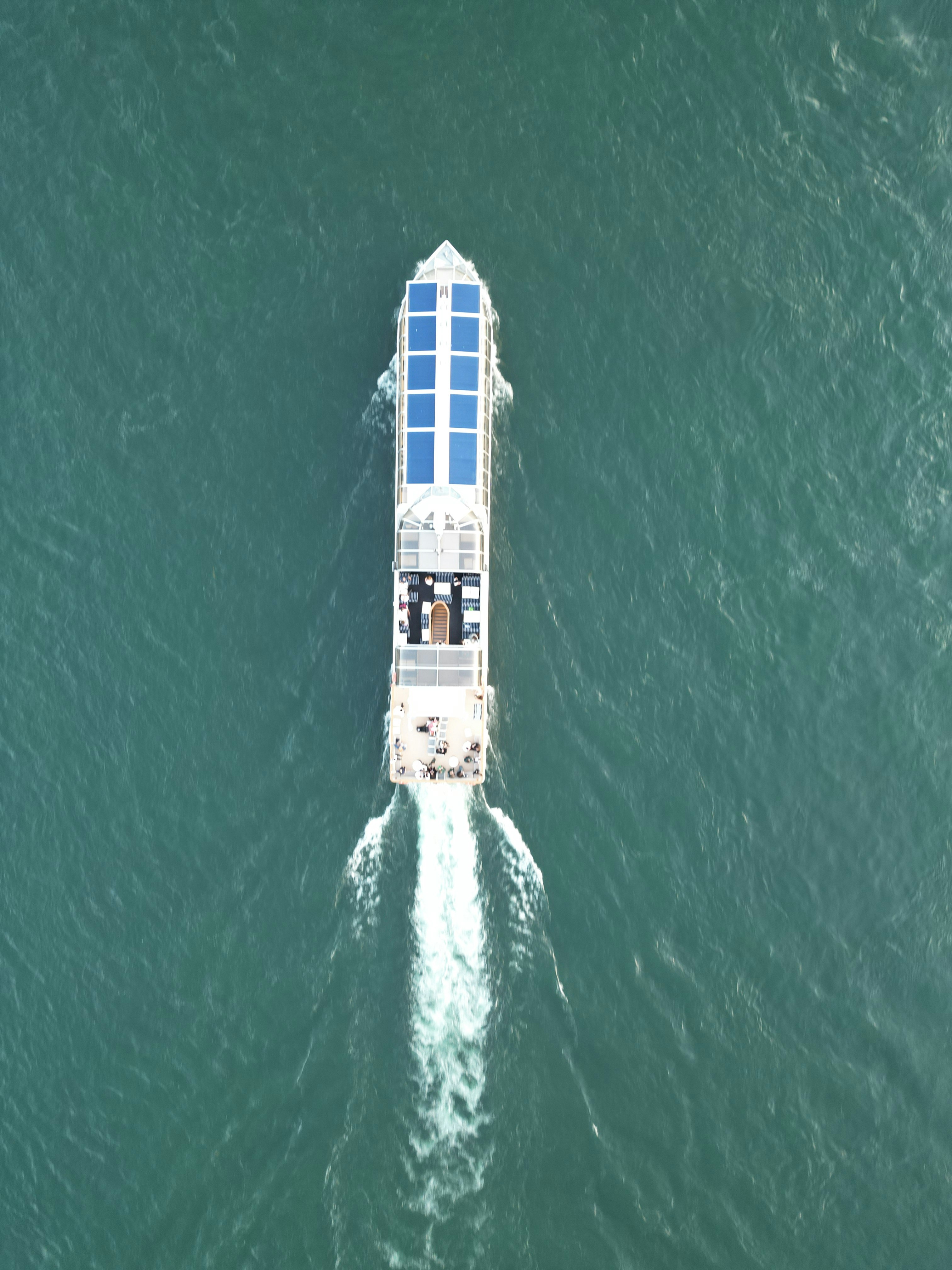 Symmetrical Drone View: A Blue-Ribbon Vessel Cutting Through Teal Waters