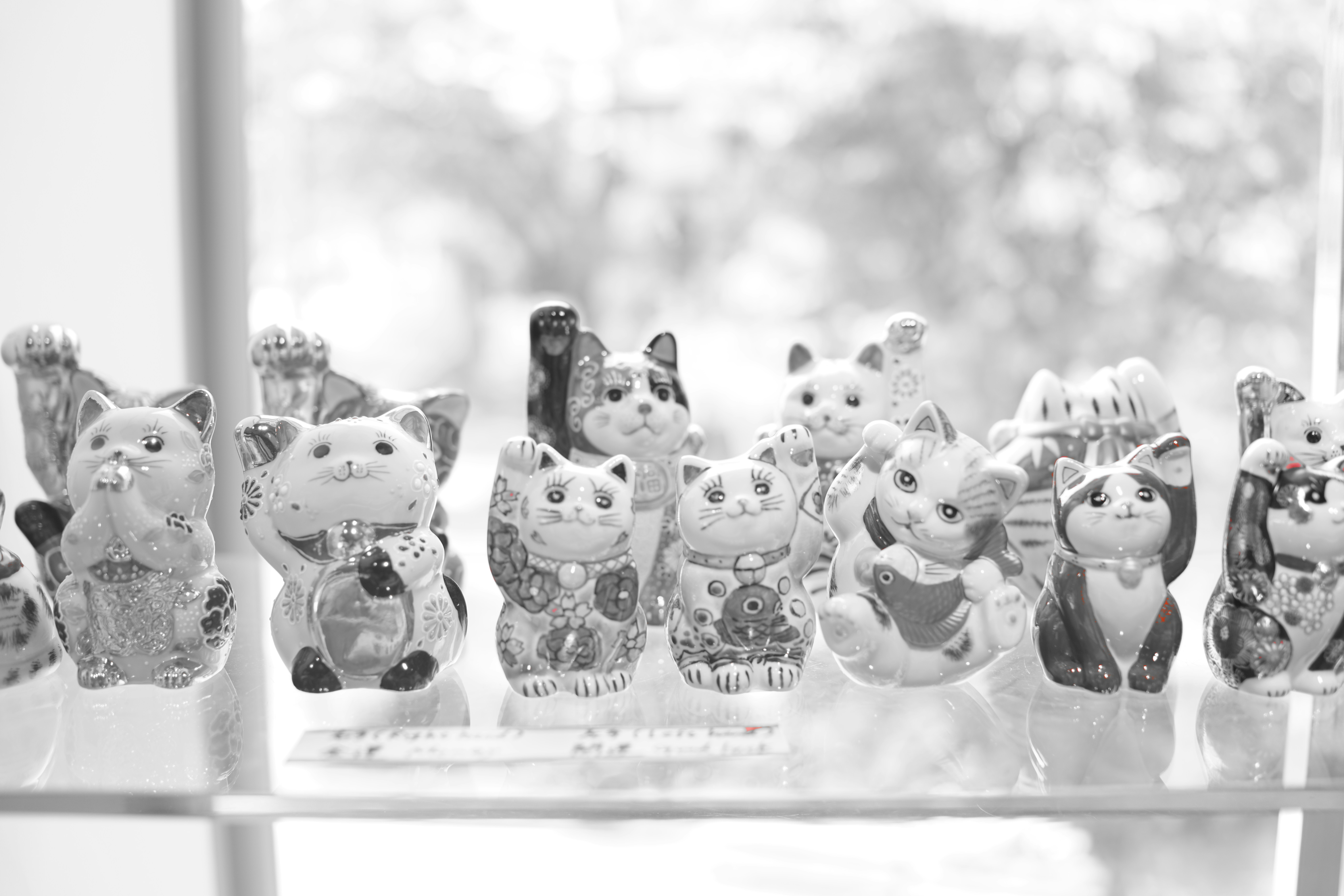 Maneki neko statues are displayed on a shelf.