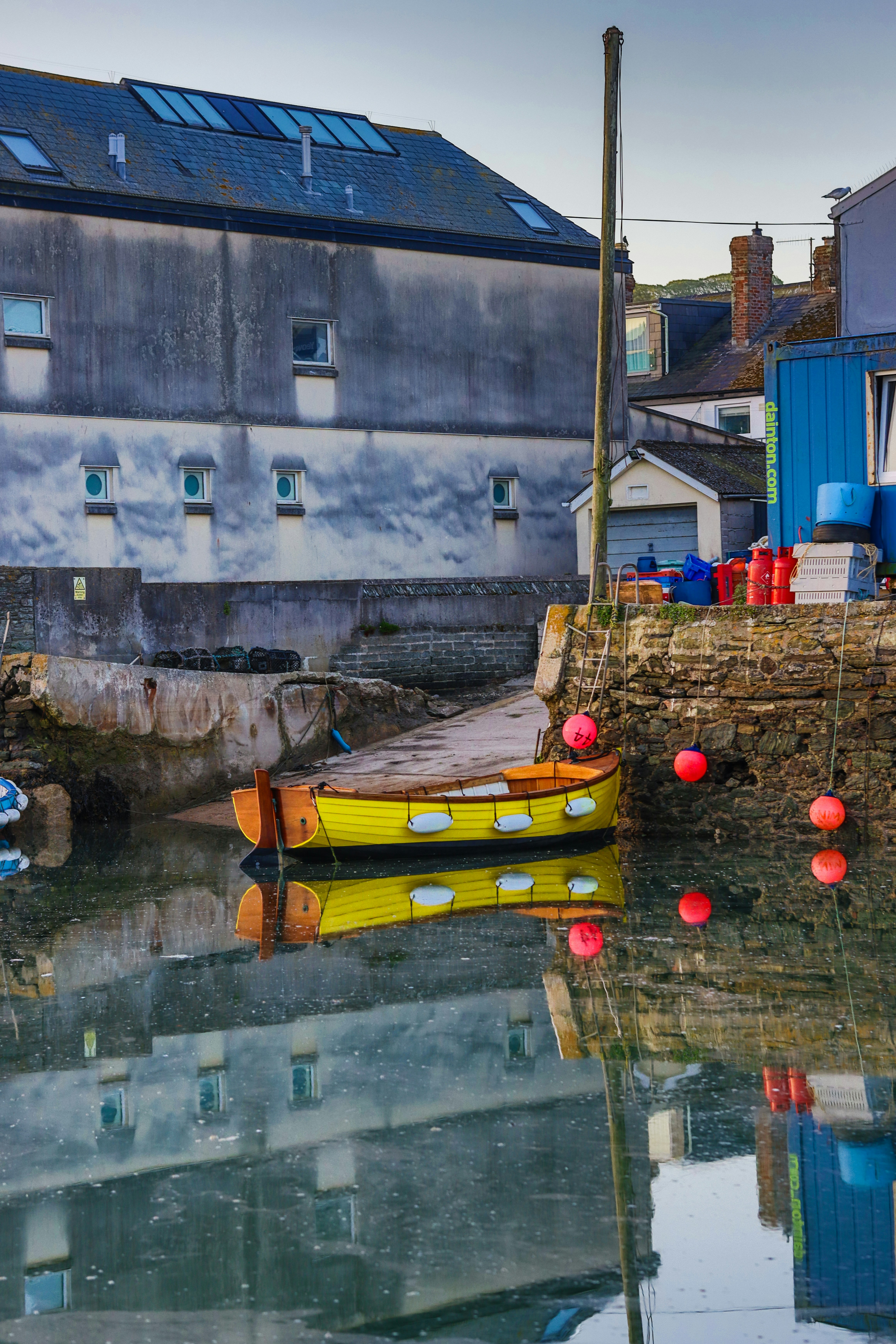 A yellow boat rests peacefully in the calm harbor. photo – Free City ...