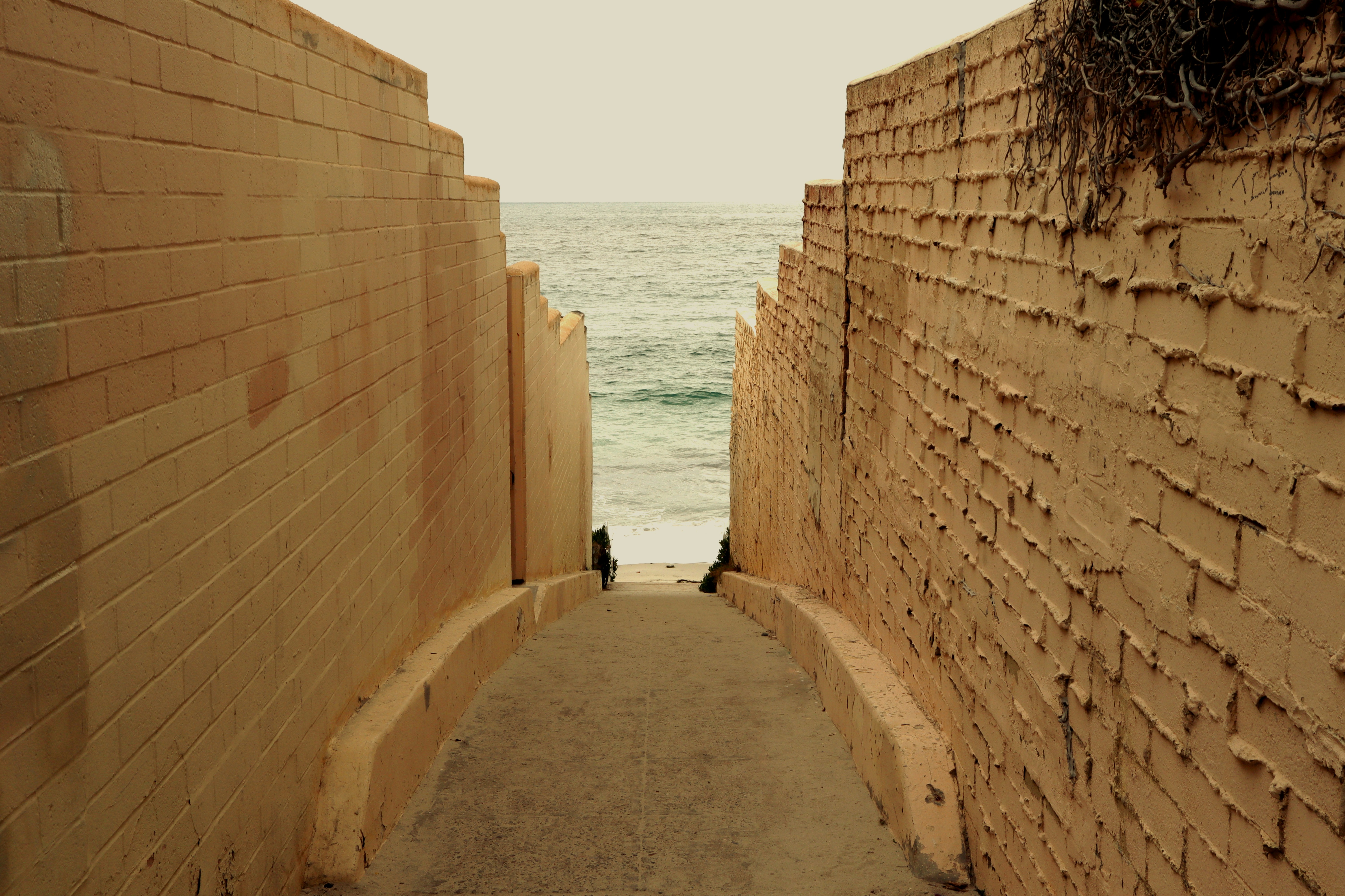 A pathway between walls leads to the sea. photo – Free Sea Image on ...