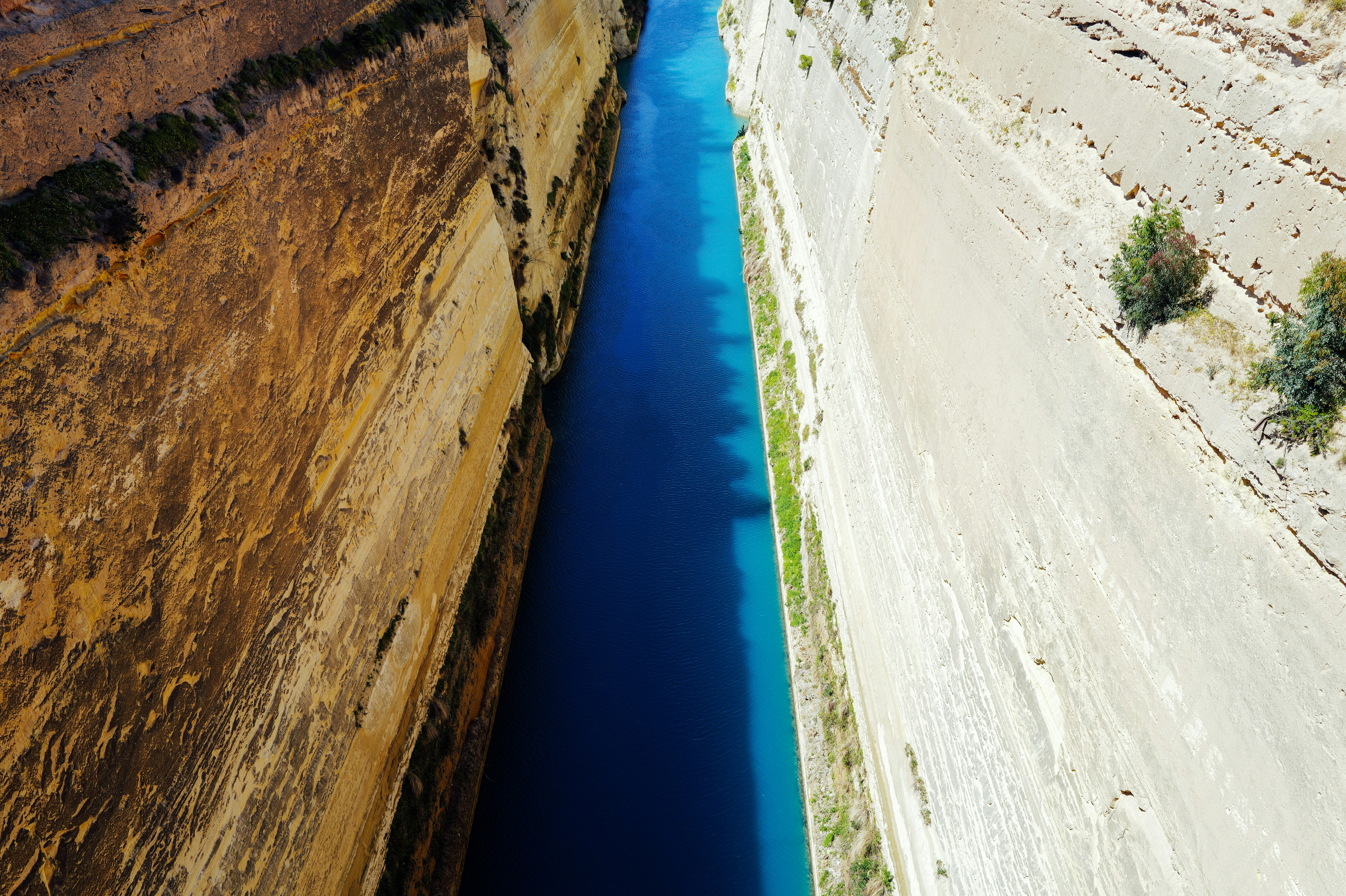 A deep blue canal carved through stone walls. photo – Free River Image ...