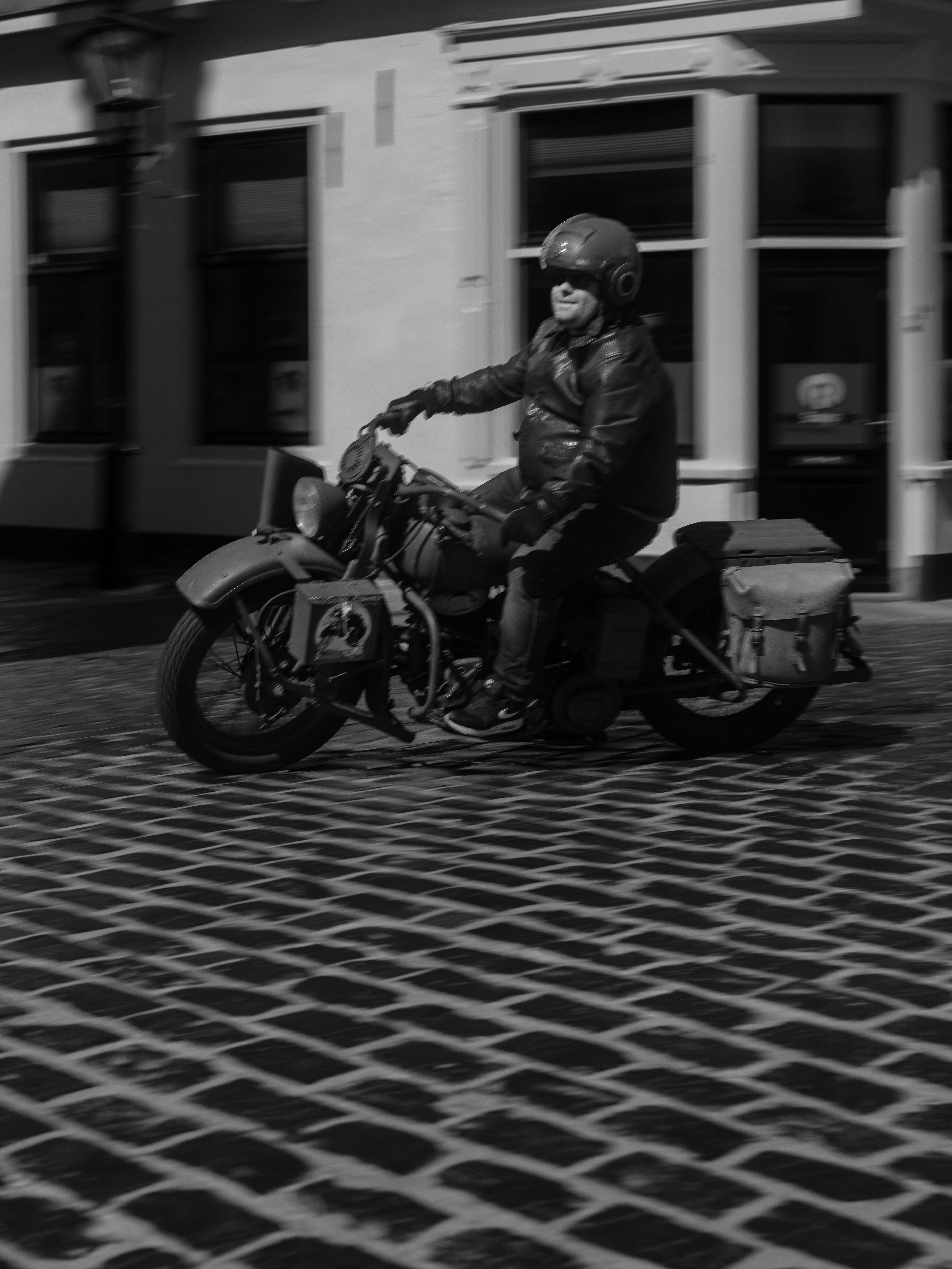 Monochrome Cobblestone Drift: A Vintage Rider in Motion