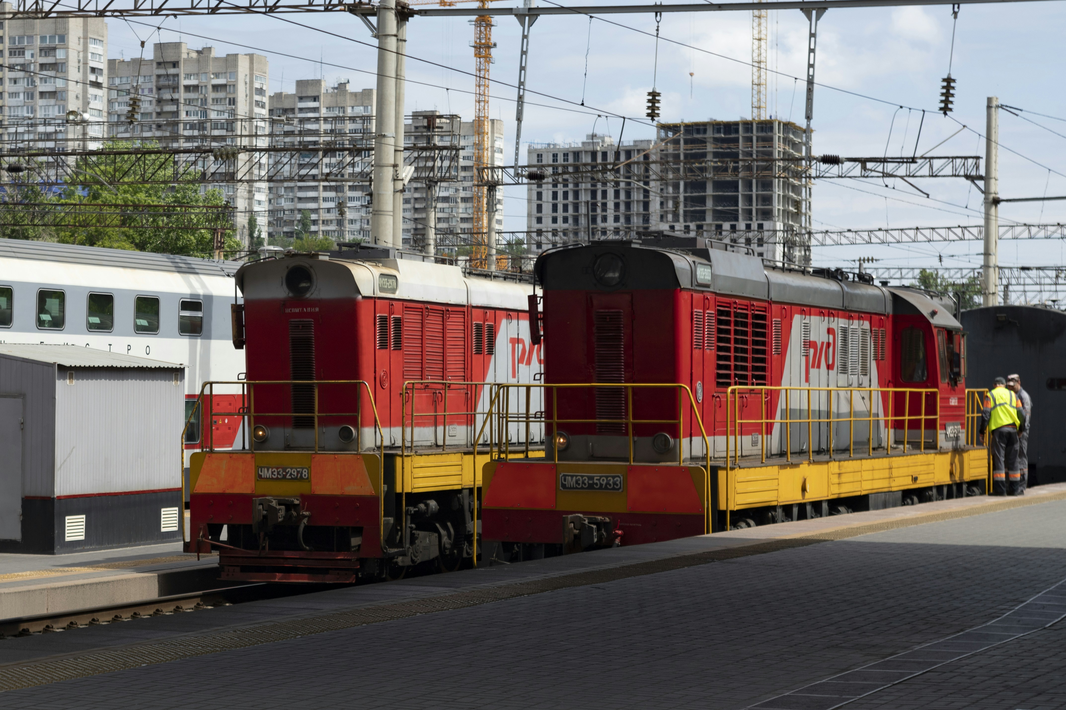 Twin Red Locomotives Idle at a City-edge Rail Yard