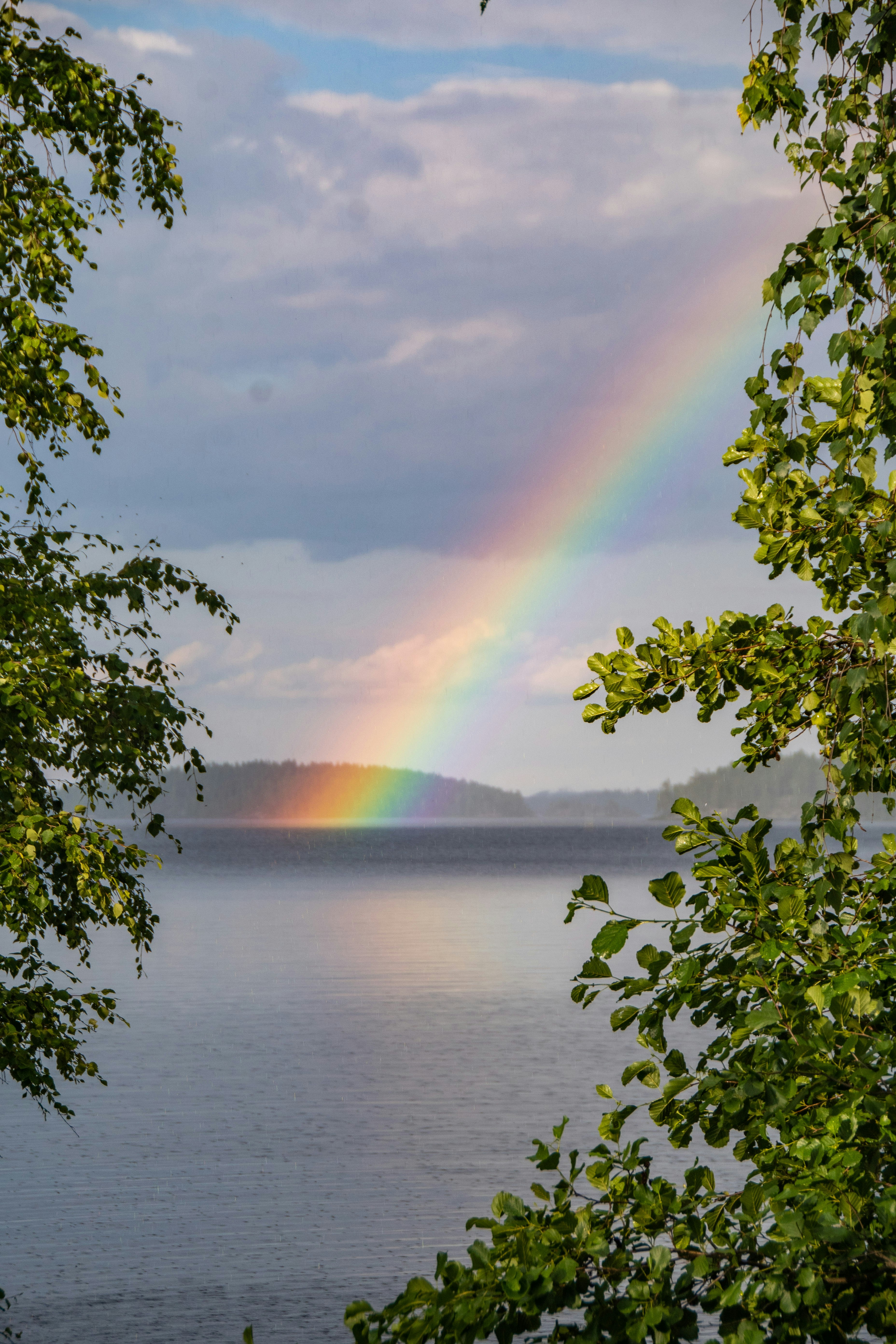 A beautiful rainbow arches over the water. photo – Free Rainbow Image ...