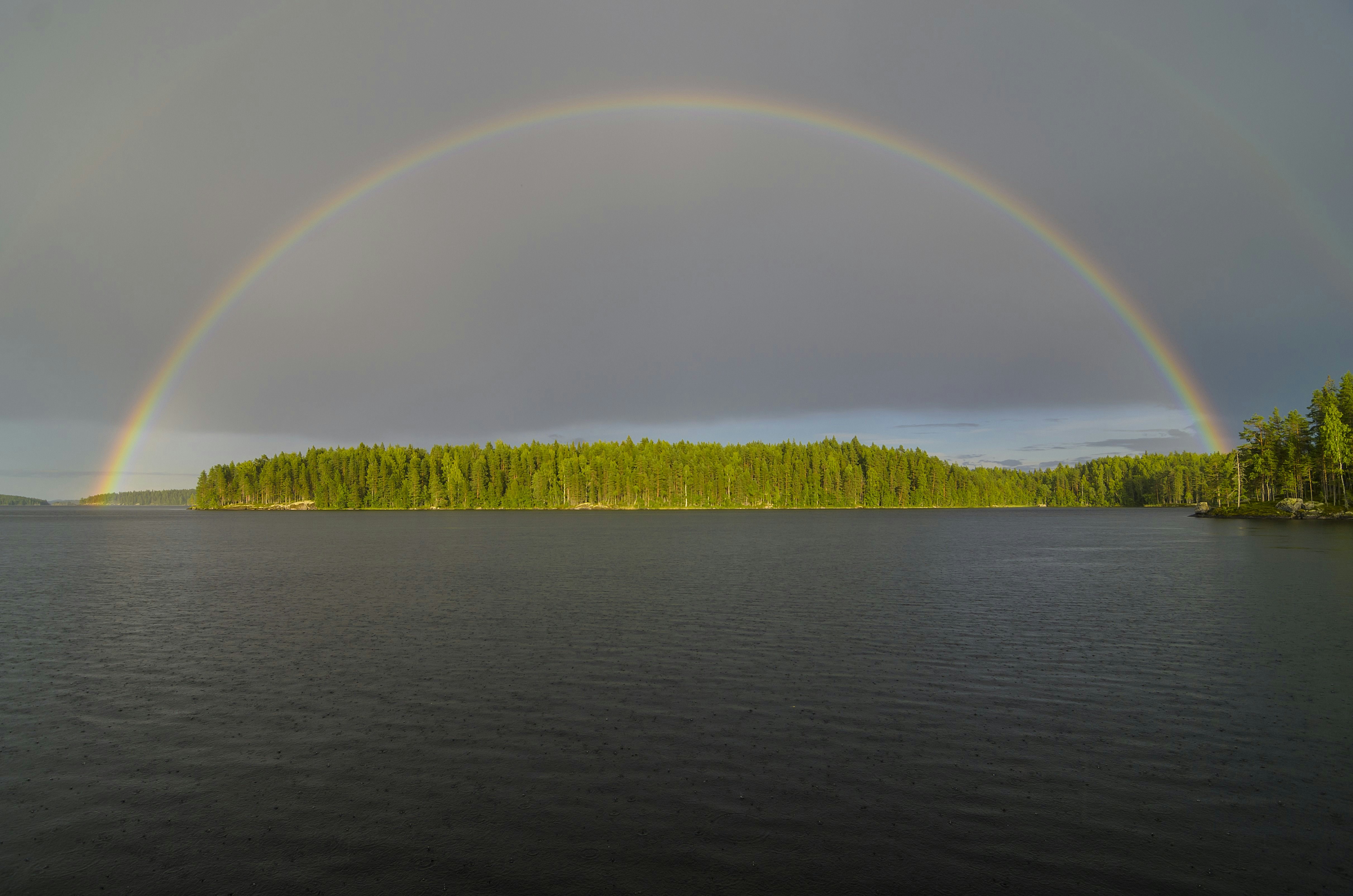 Twin Arcs Over Quiet Waters: A Full-Width Rainbow Across the Lake