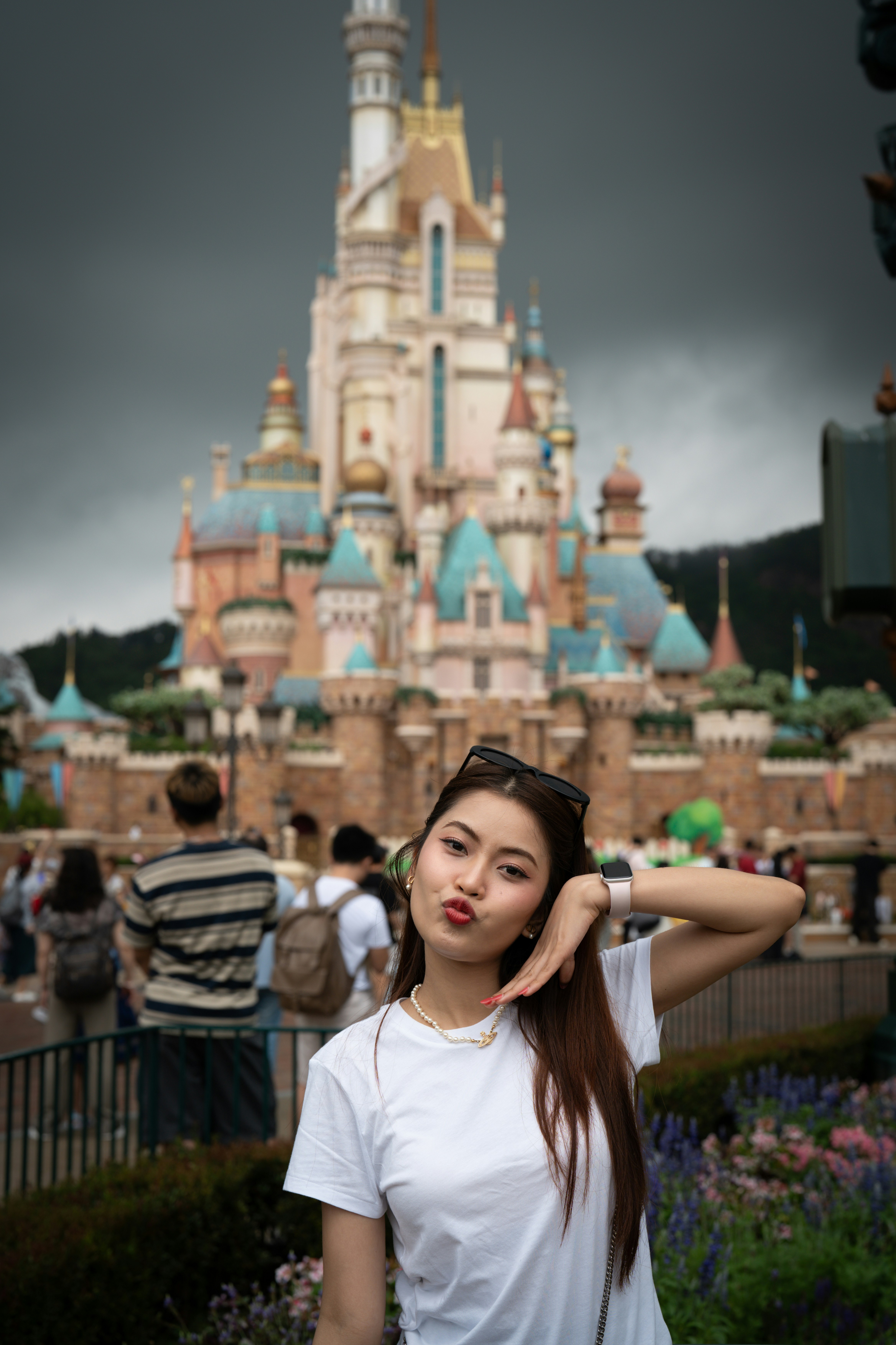 A woman poses in front of a disney castle. photo – Free Woman Image on ...
