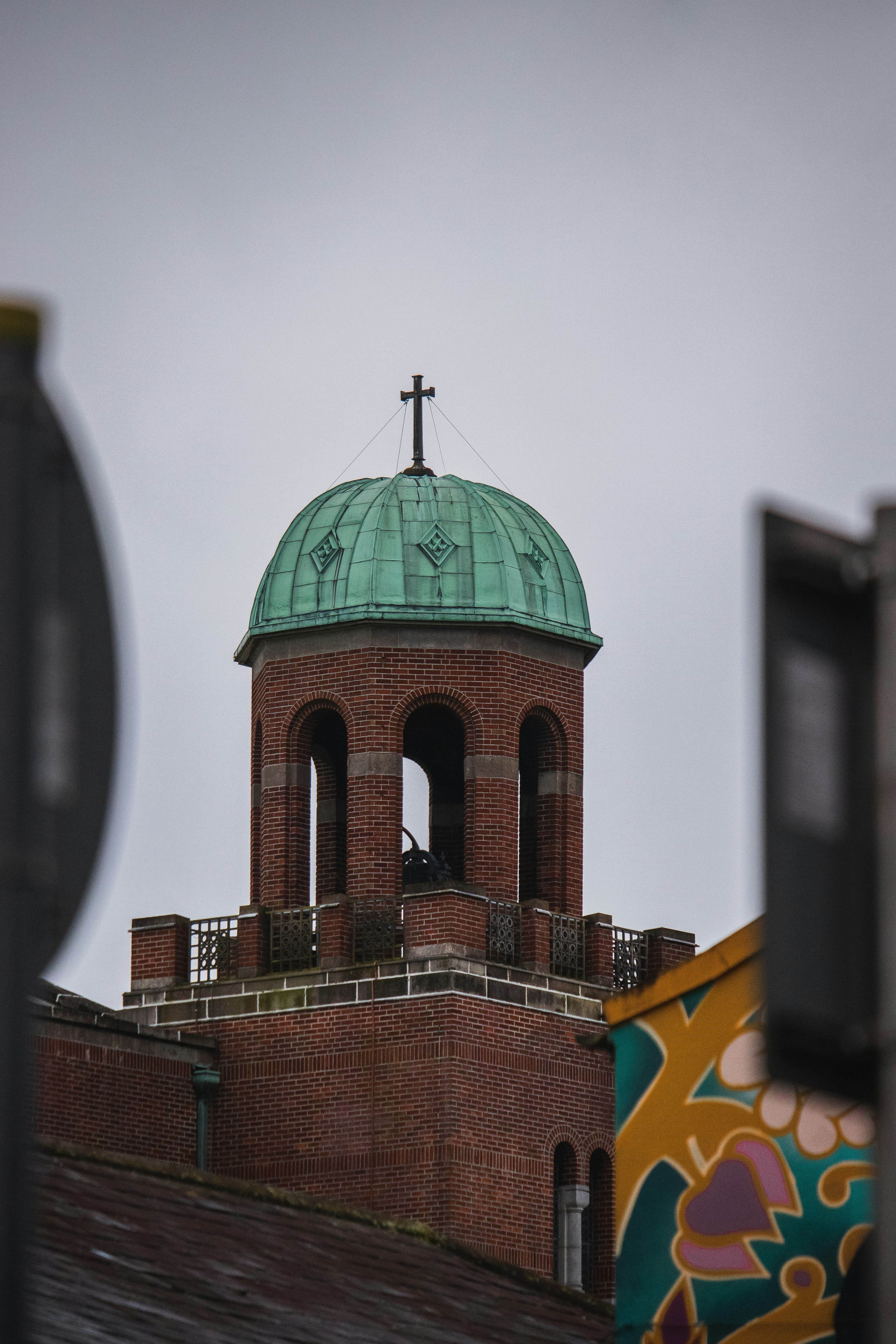 Verdigris Dome Over Brick Bell Tower Framed by Street Graffiti