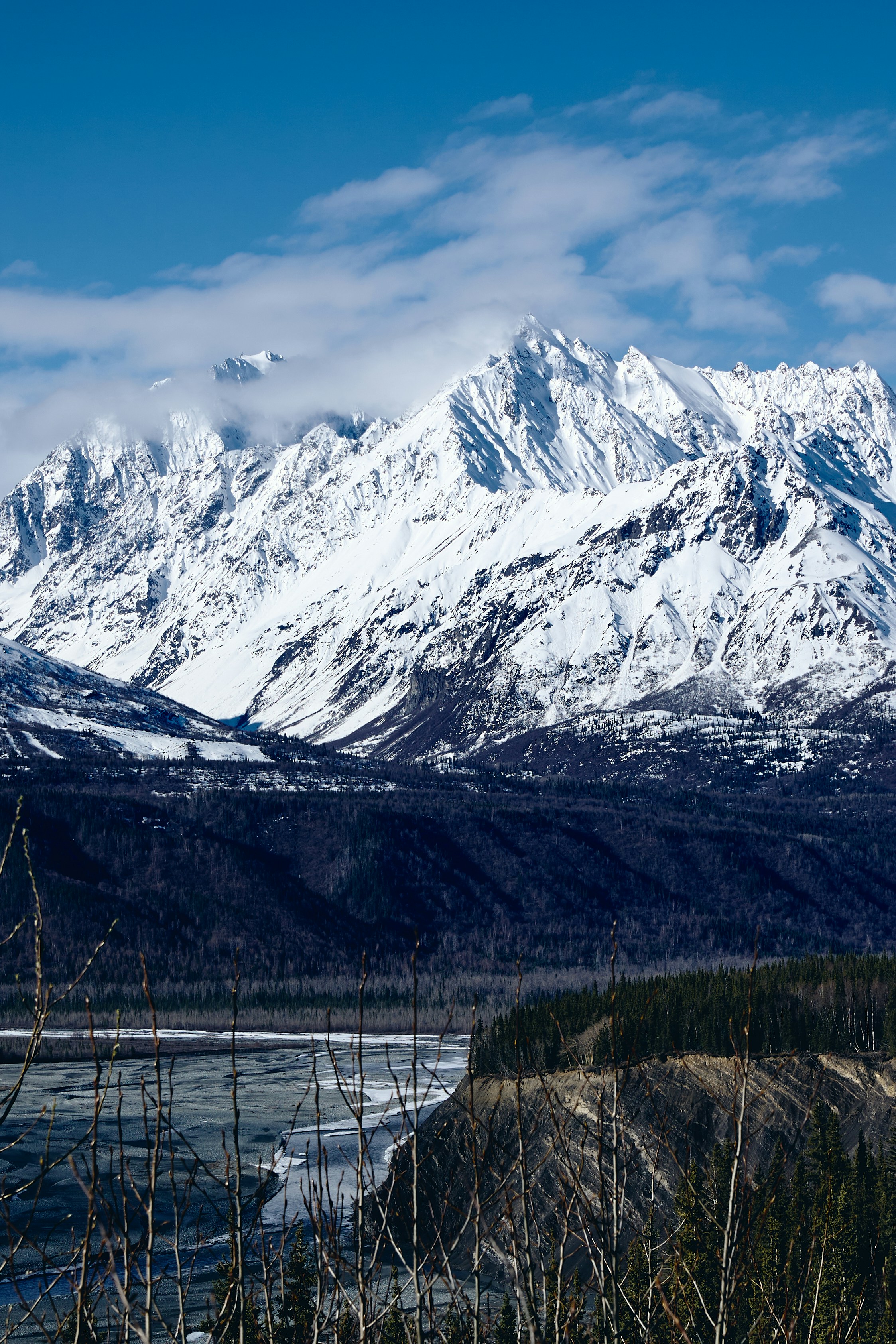 Snowy mountains tower over a dark landscape.