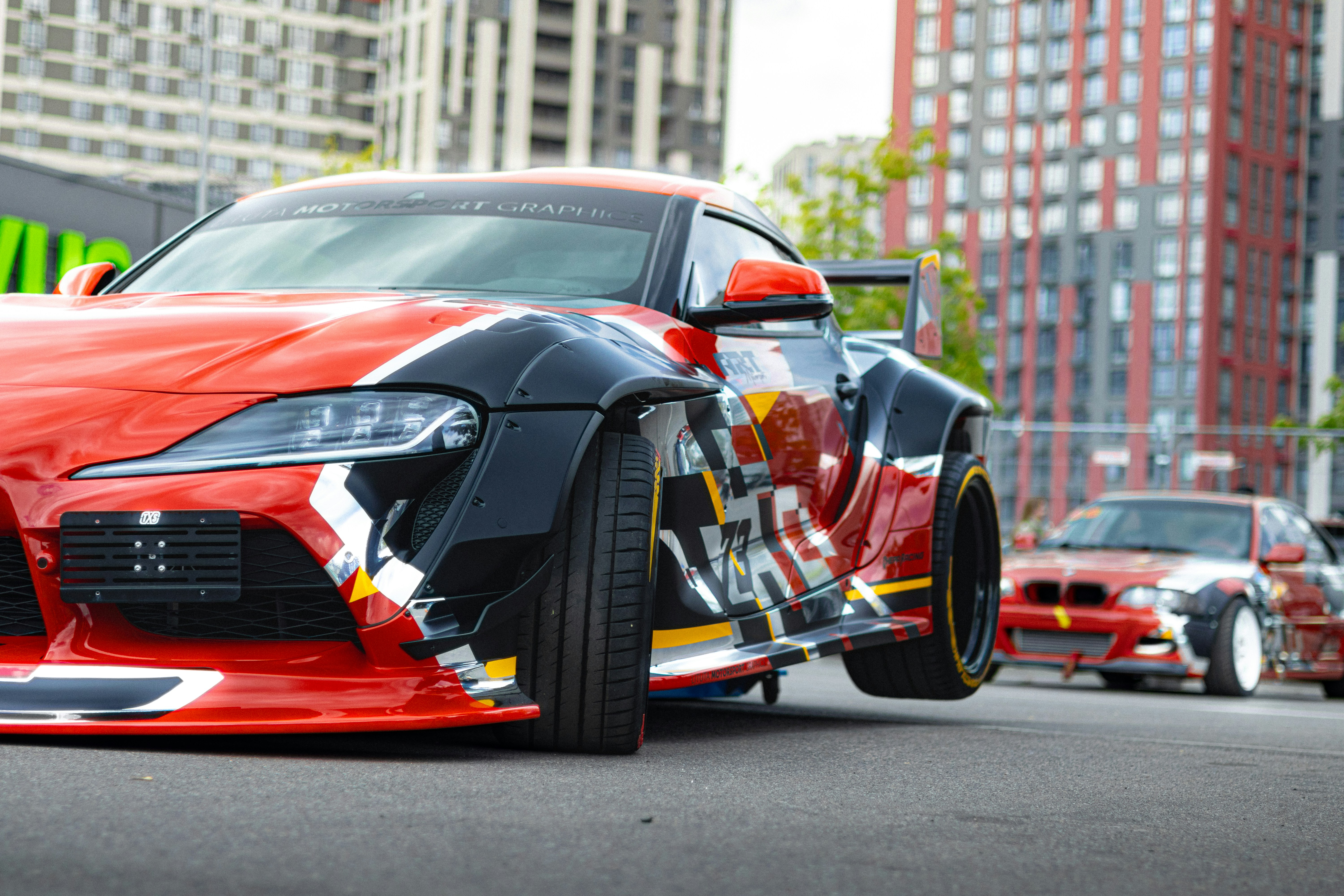 Customized sports cars are parked outdoors in a city. photo – Free ...
