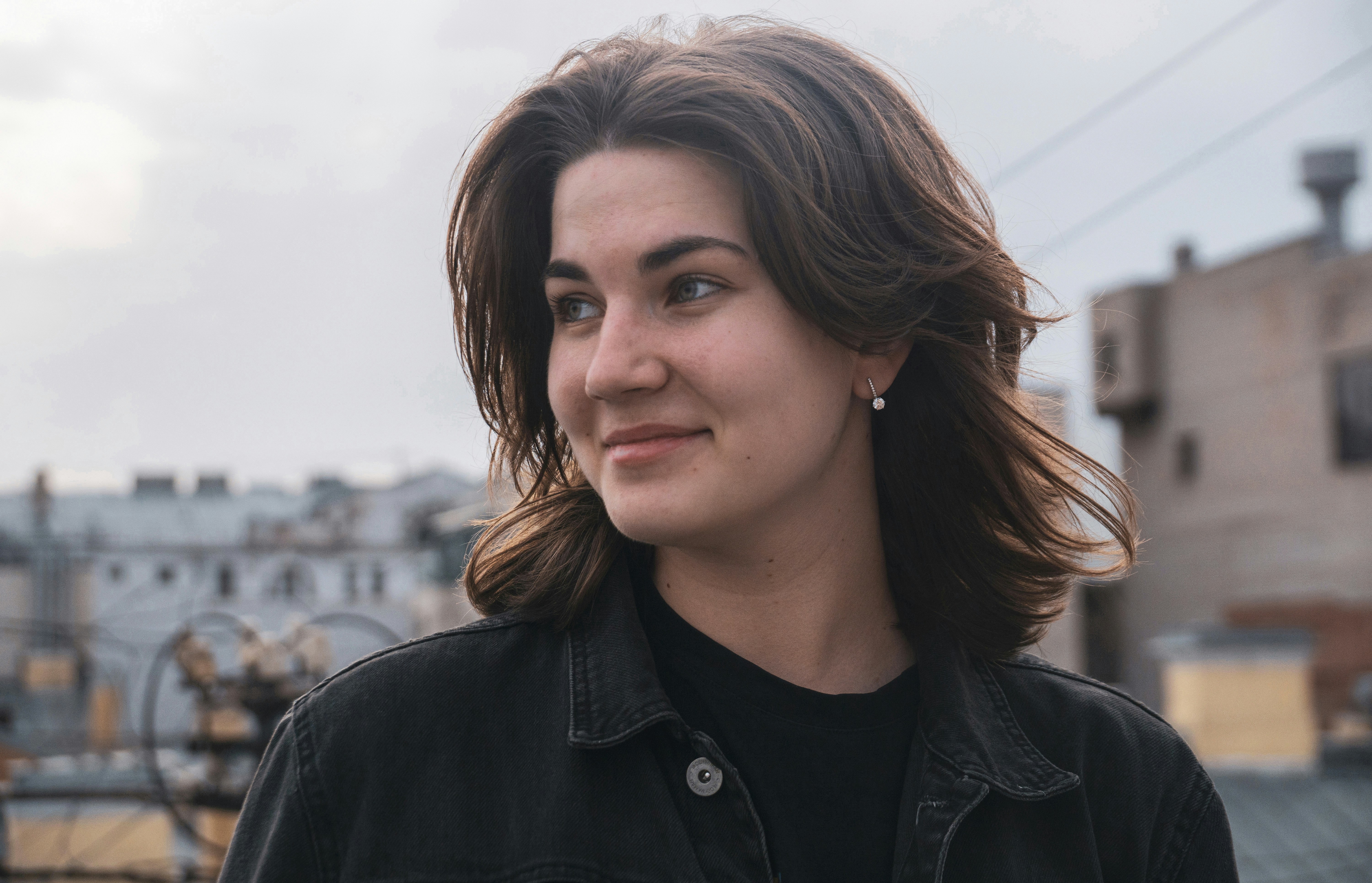 Young woman smiles on a rooftop.