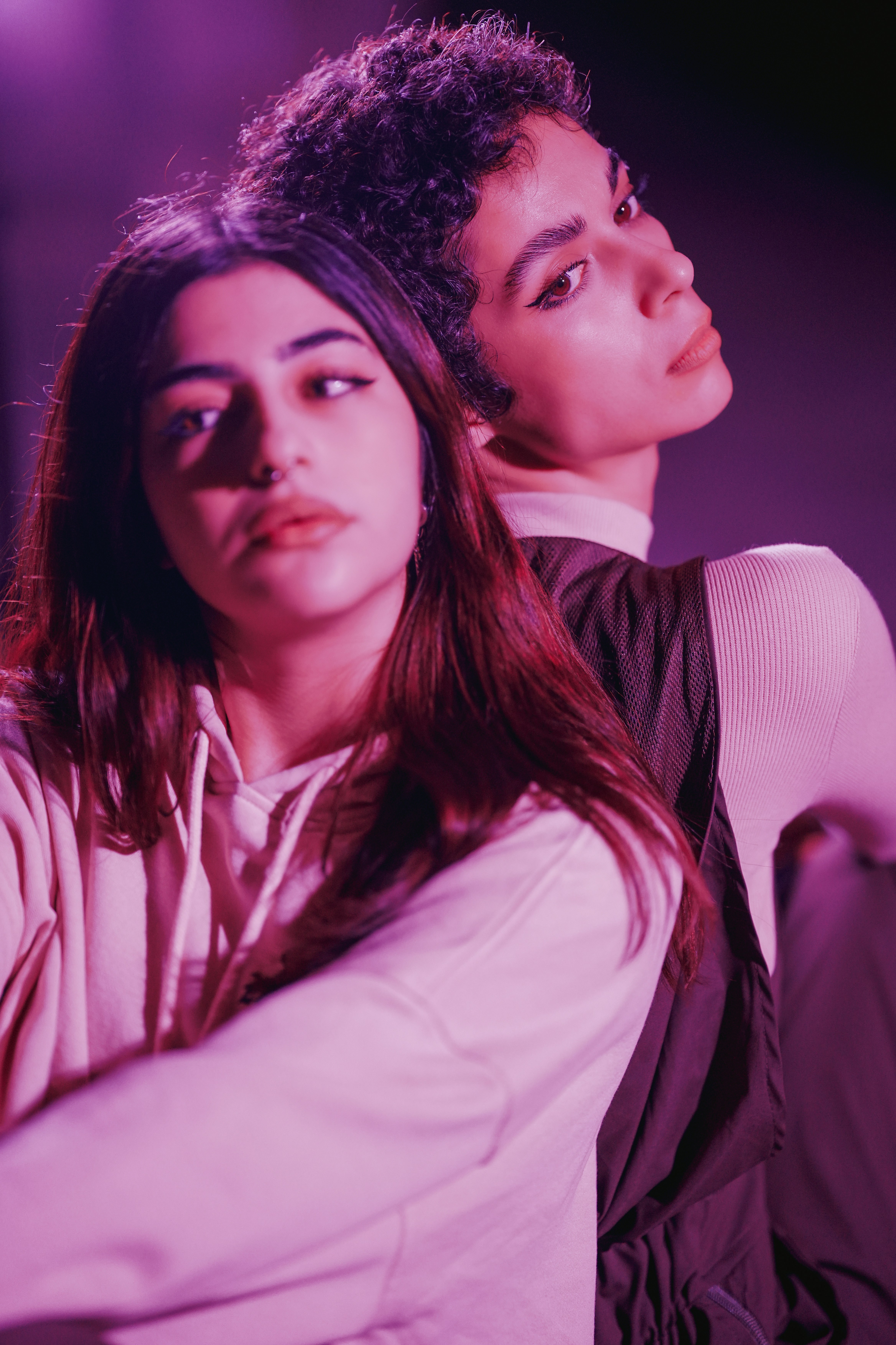 Two people pose together, lit with purple. photo – Free Image on Unsplash