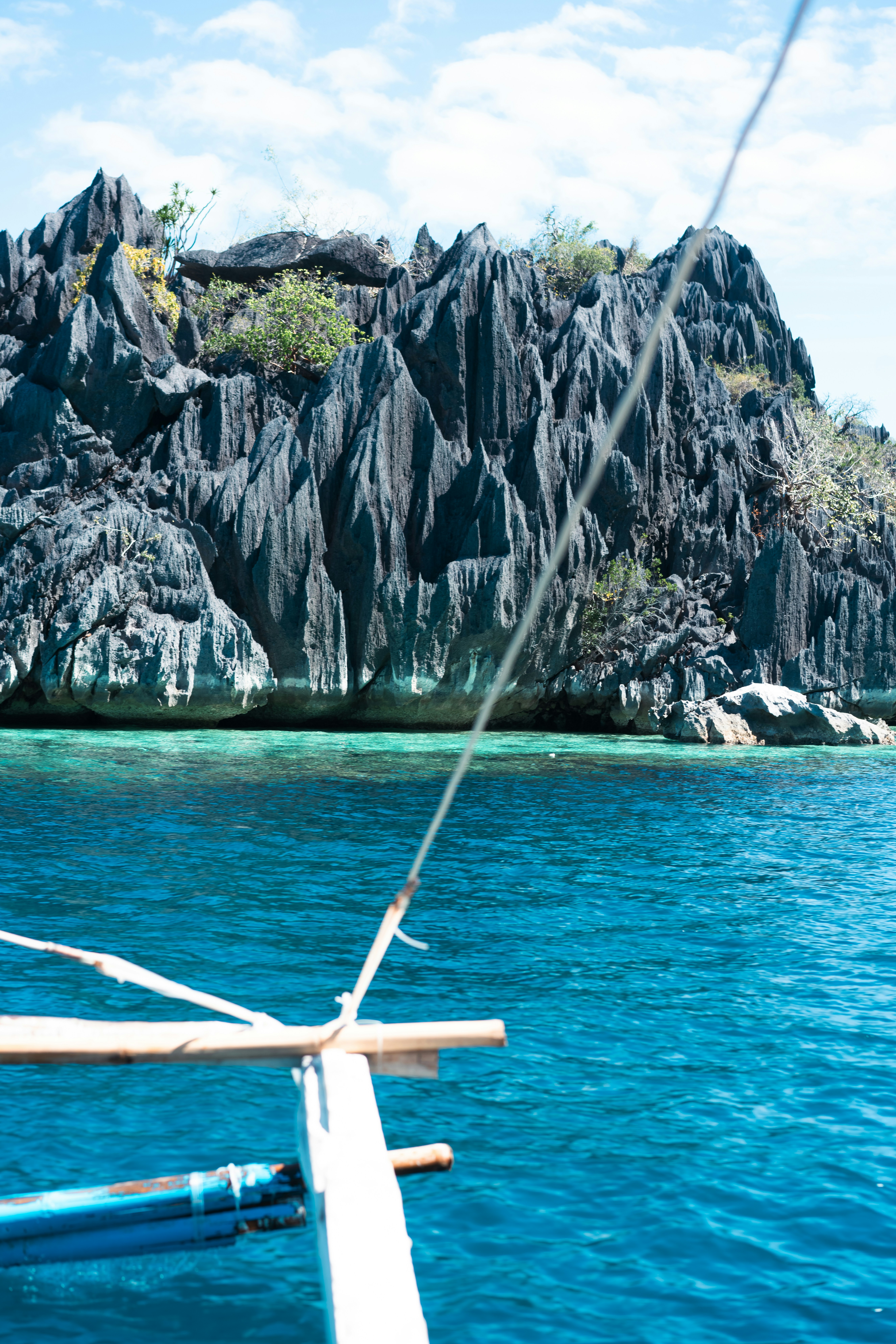 Rigging the Blue Expanse: A Boat Silhouette Against Limestone Peaks