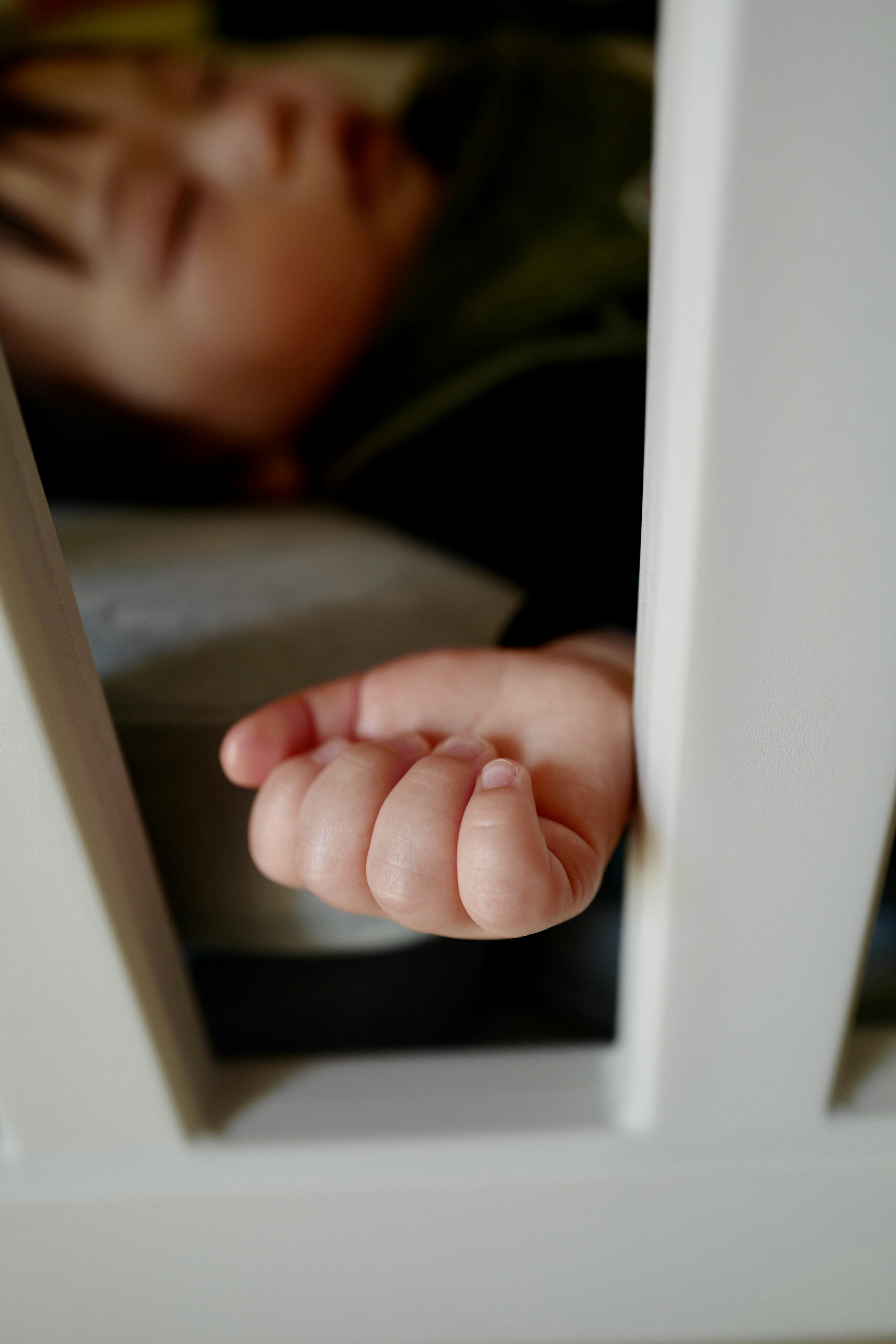 A sleeping baby's hand grasps the crib rails. photo – Free Baby hand ...