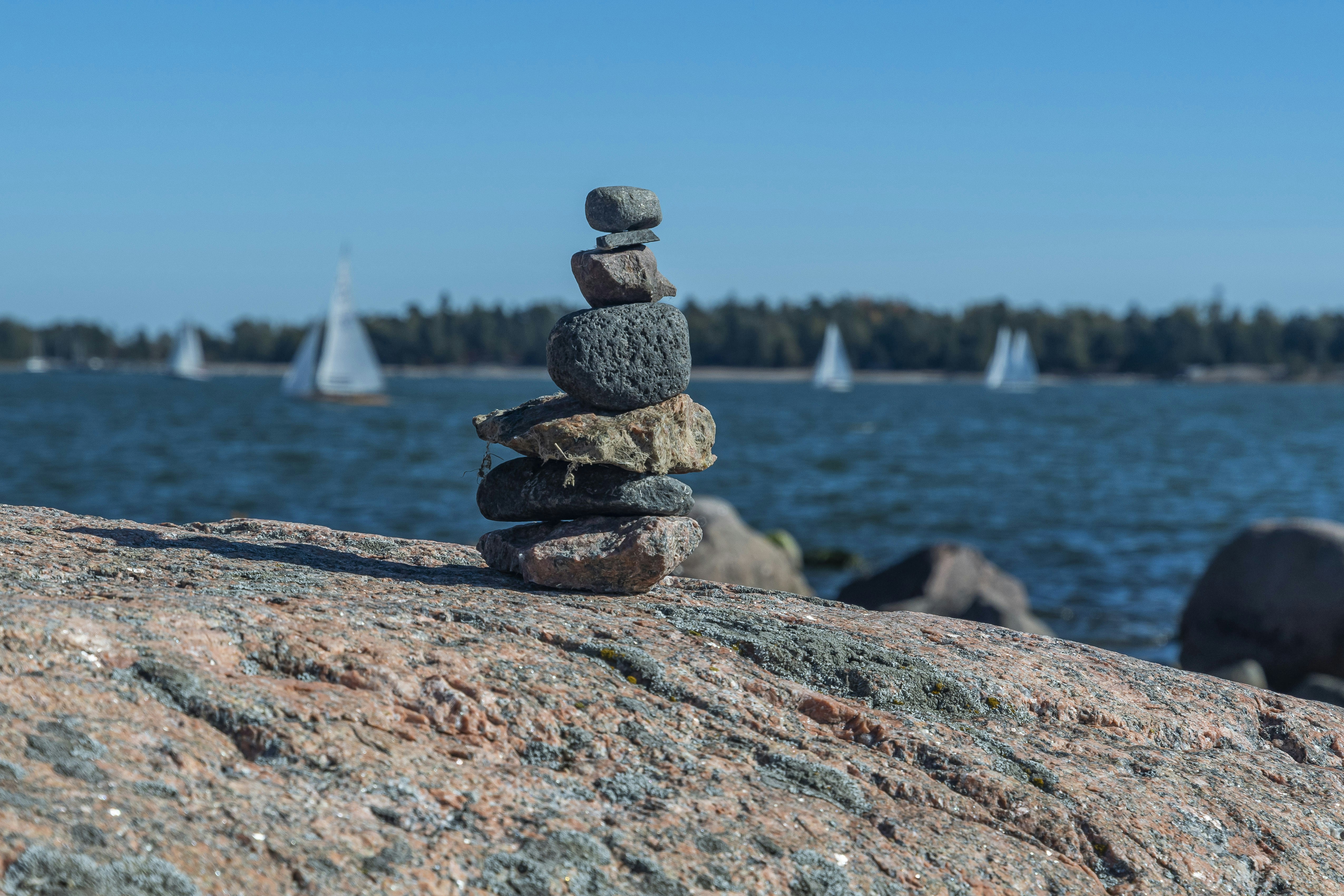 A stack of stones sits on a coastal rock. photo – Free Rocks Image on ...