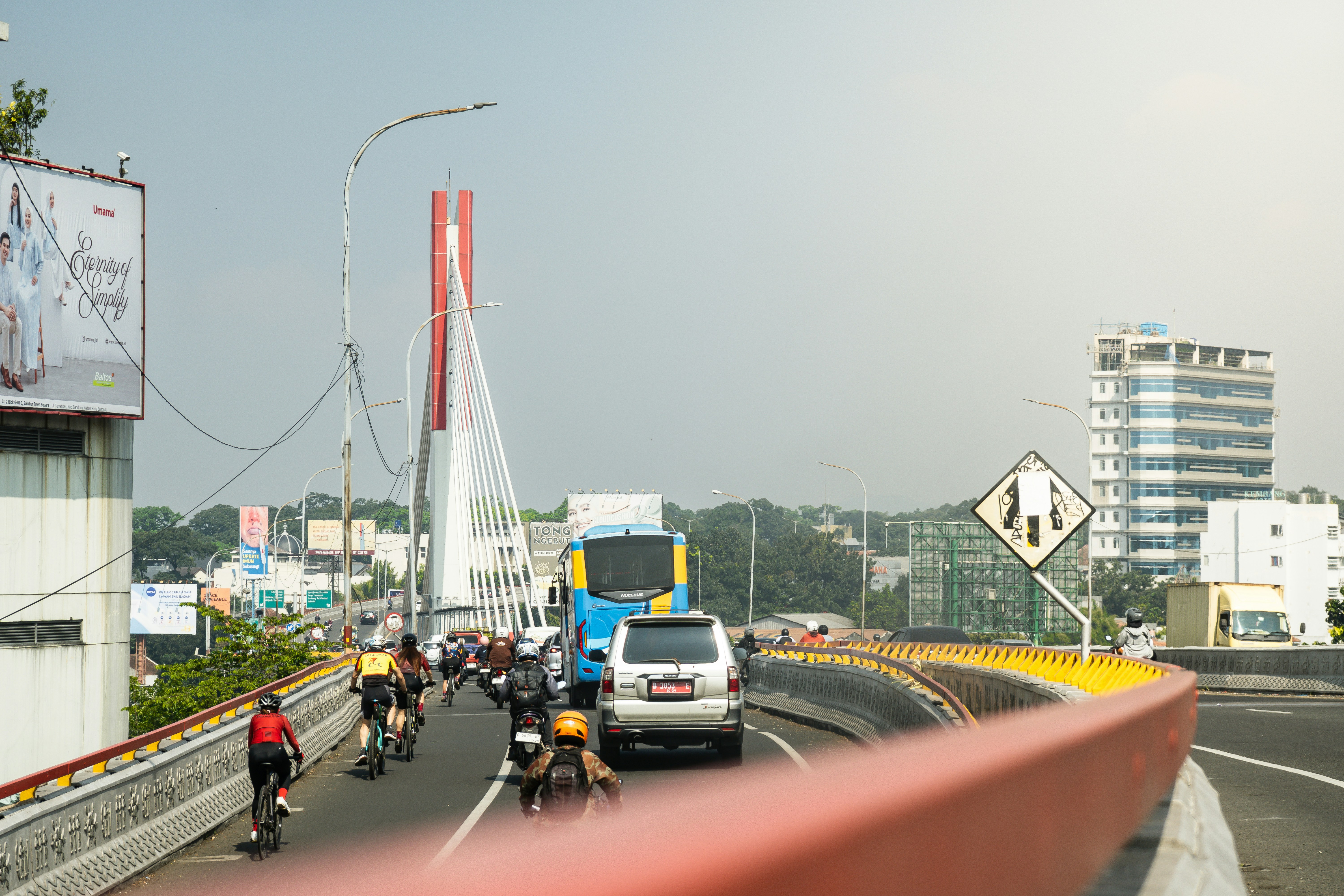 Cars, cyclists, and buses travel on a bridge. photo – Free Street ...