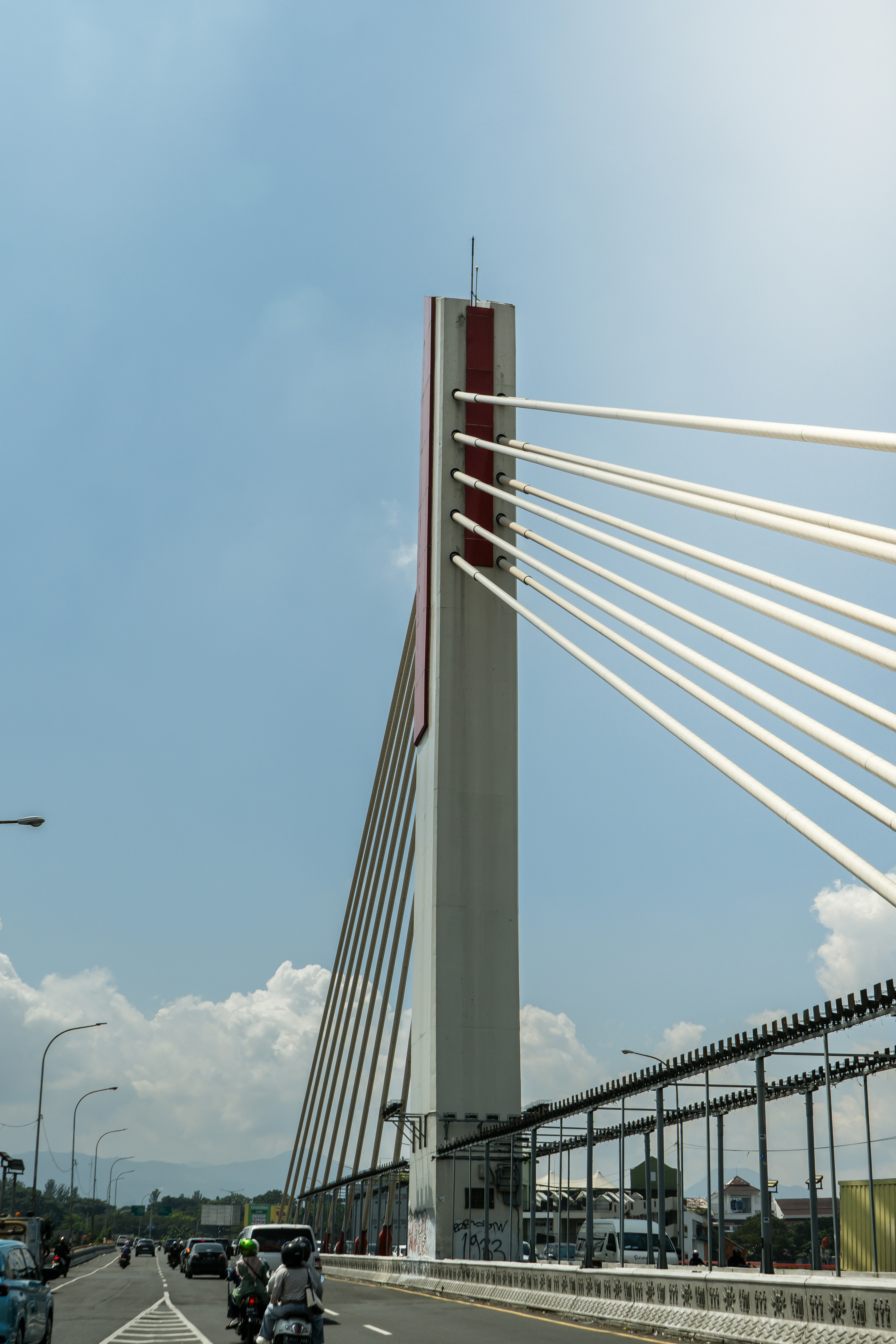 Salah satu ikon kota Bandung adalah Jembatan Pasupati | A cable-stayed bridge with vehicles.