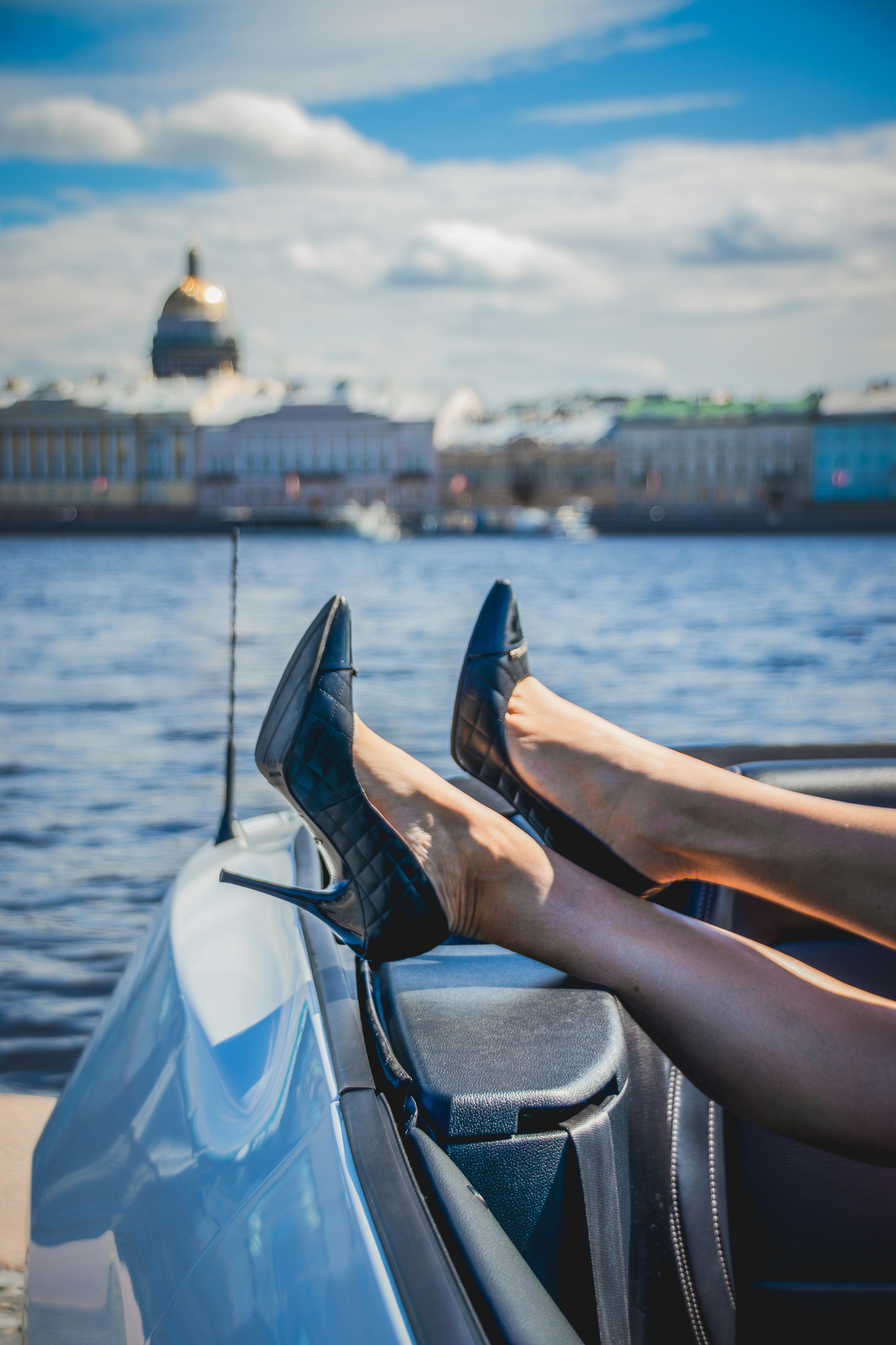 Deckside Glamour: Velvet Heels Lounge Over a Yacht With a Distant Waterfront Skyline