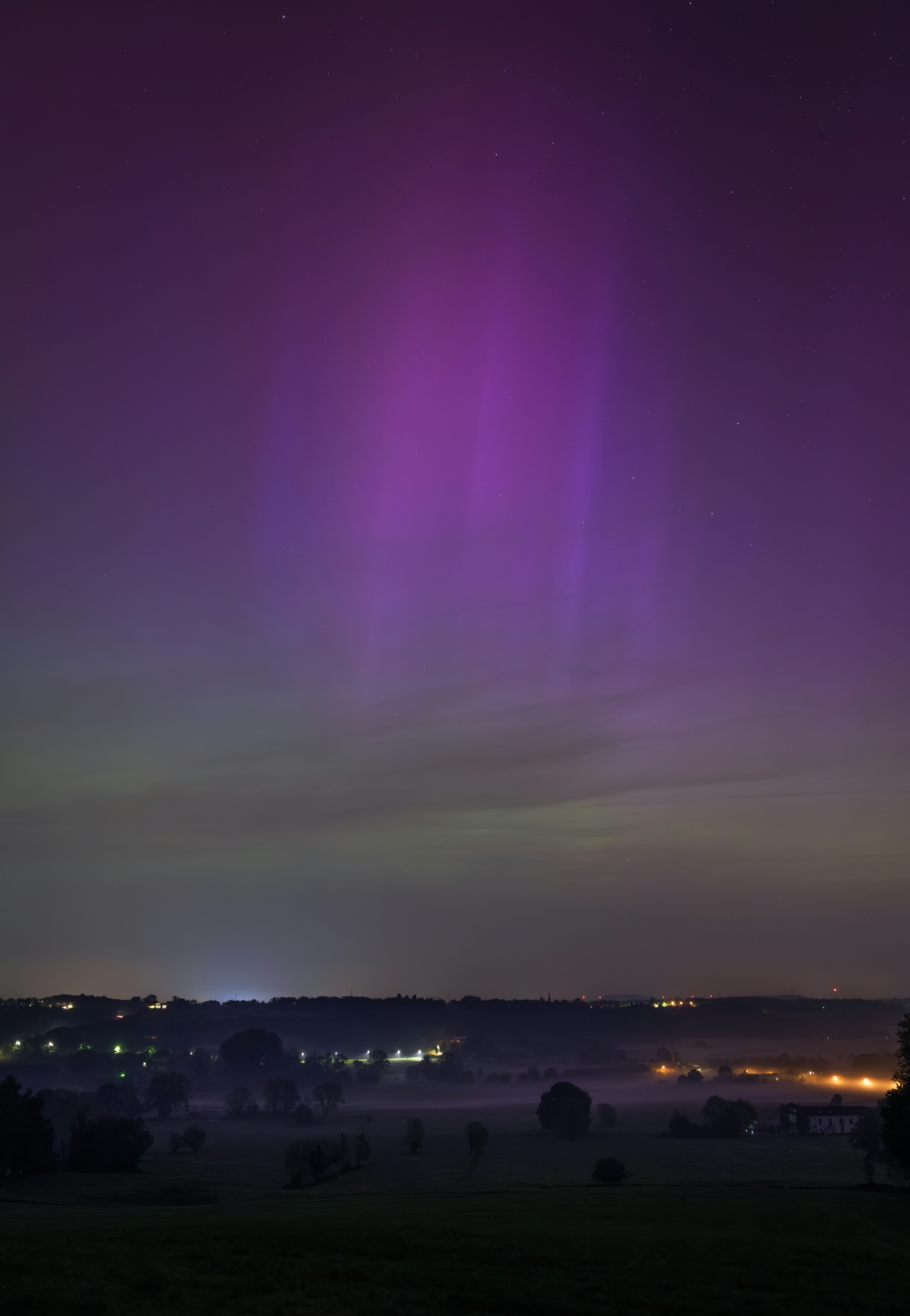Night Sky Unfolds in Violet Aurora Over Quiet Farmlands
