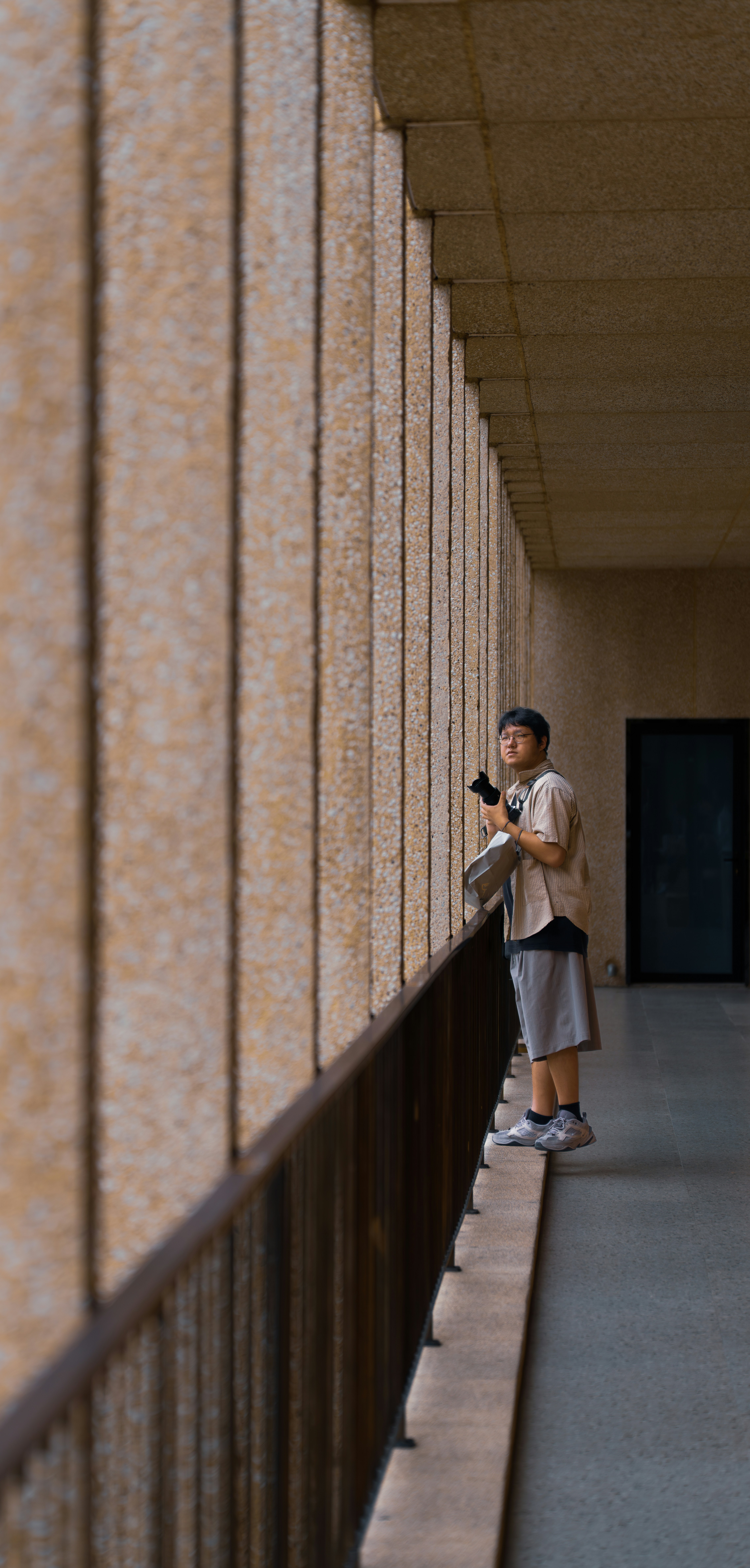 A man stands next to a row of stone columns