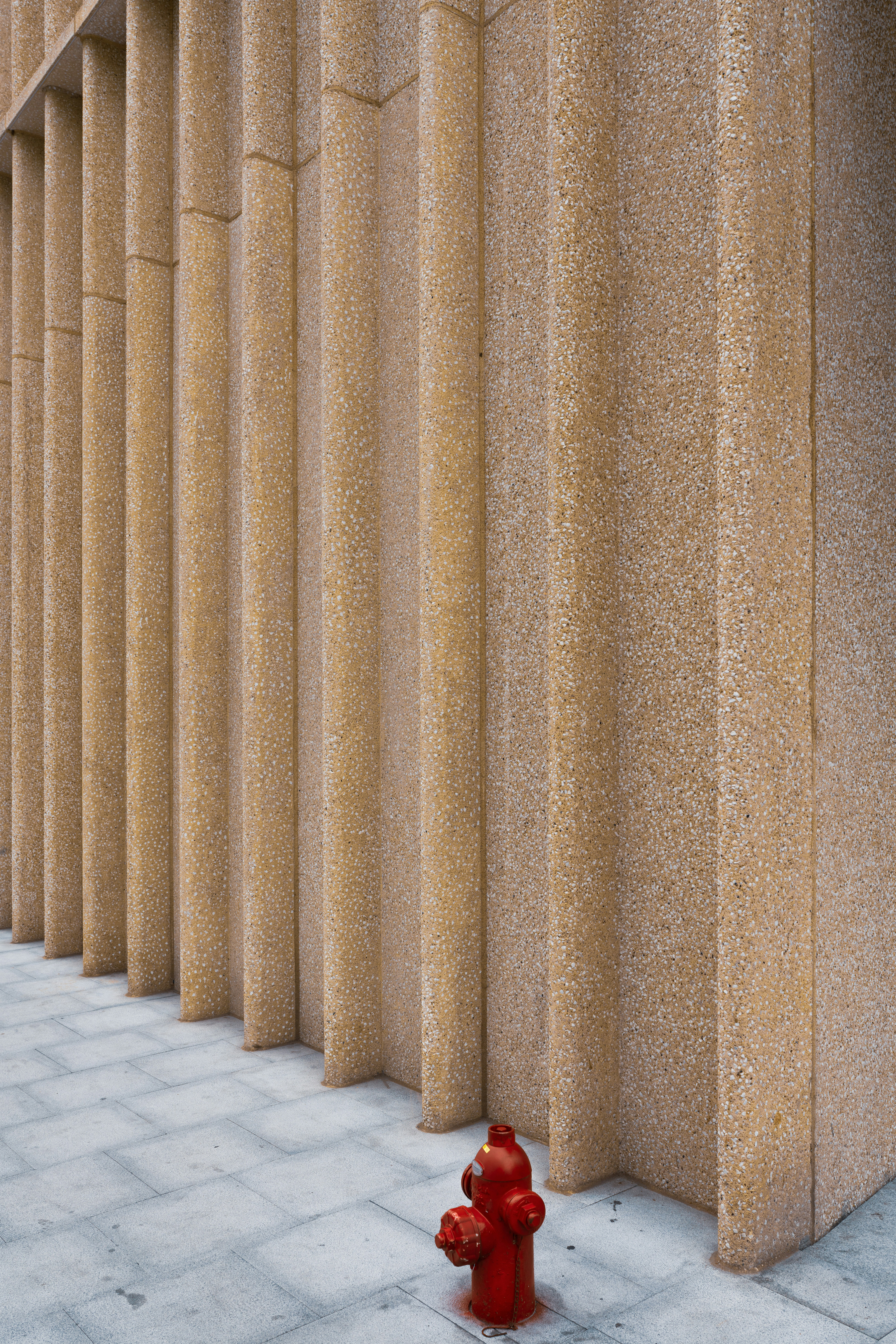Closely packed stone columns with a red fire hydrant in front