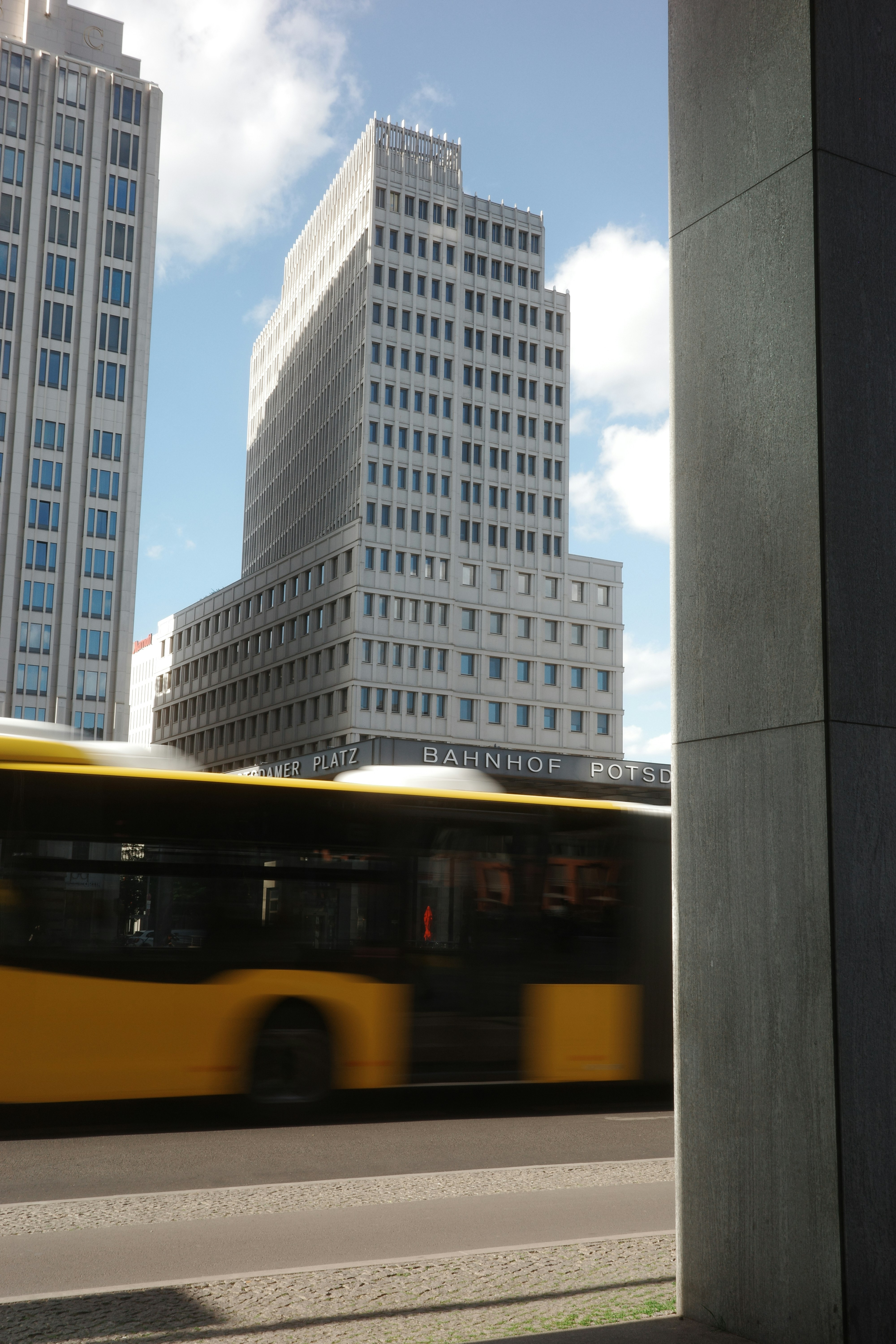 Tall buildings and a speeding yellow bus are shown. photo – Free Street ...