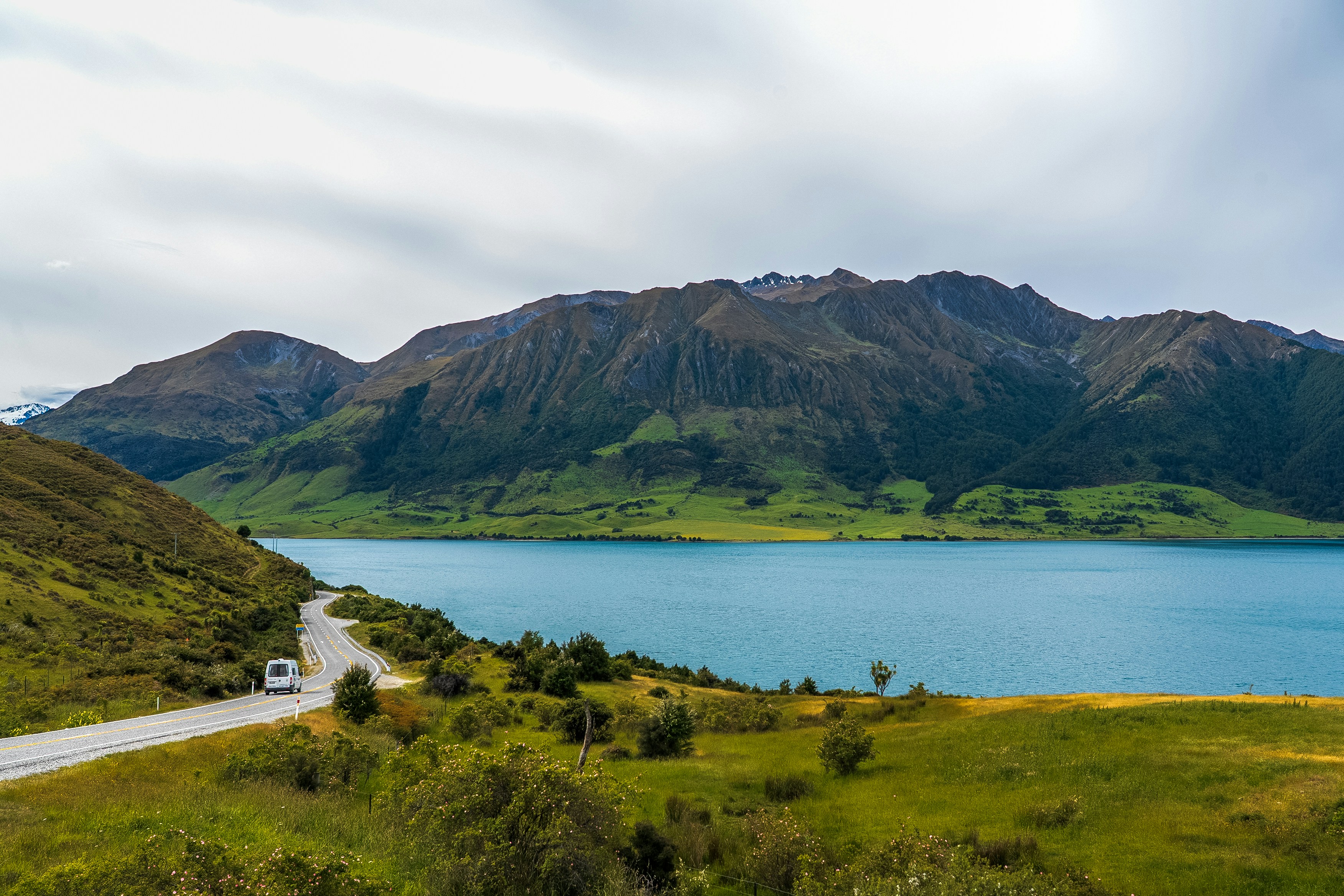 A scenic roadside view of mountains and a lake. photo – Free New zealand landscape Image on Unsplash