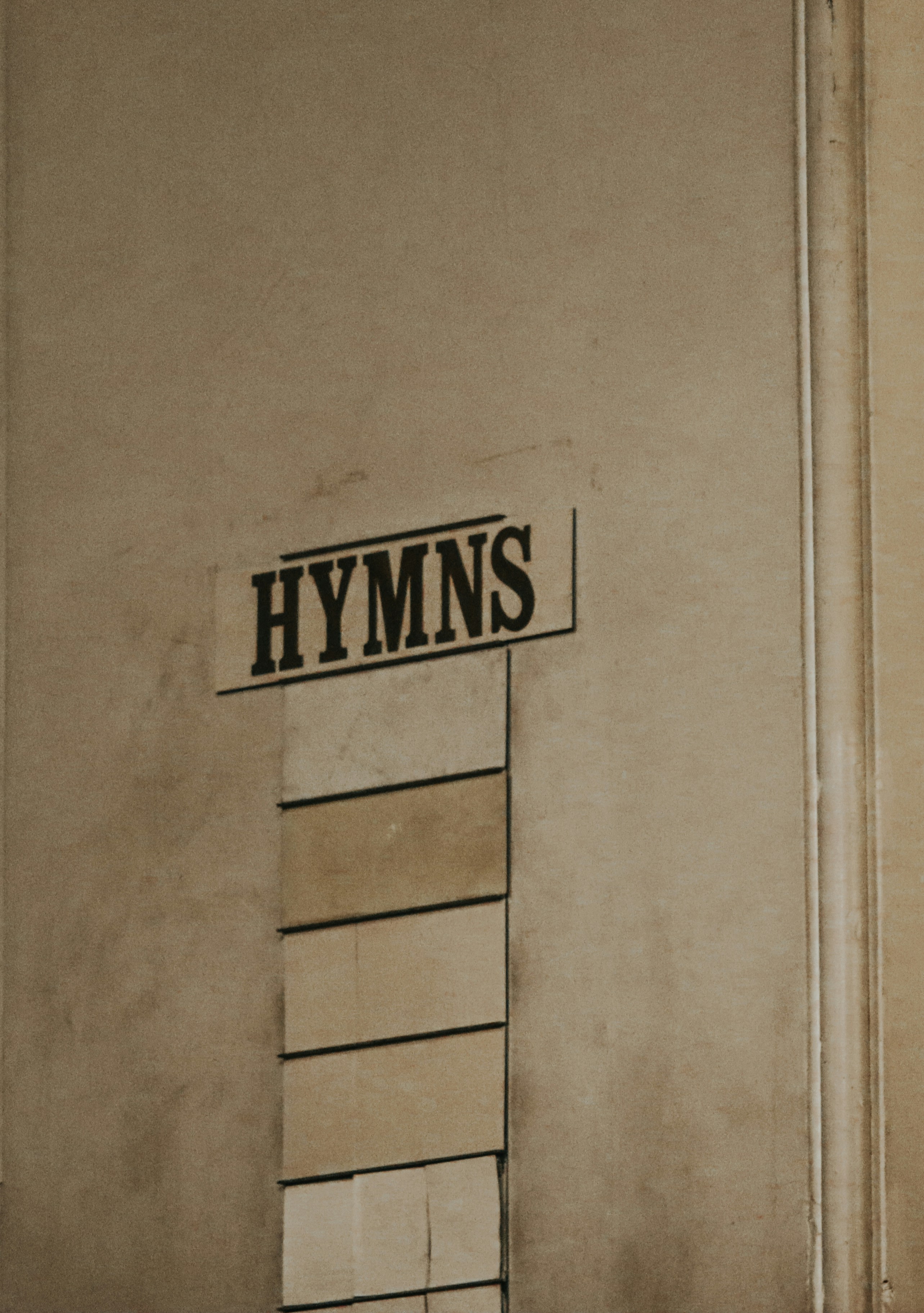 The sign reads "hymns" on an old wall. photo – Free Church Image on ...