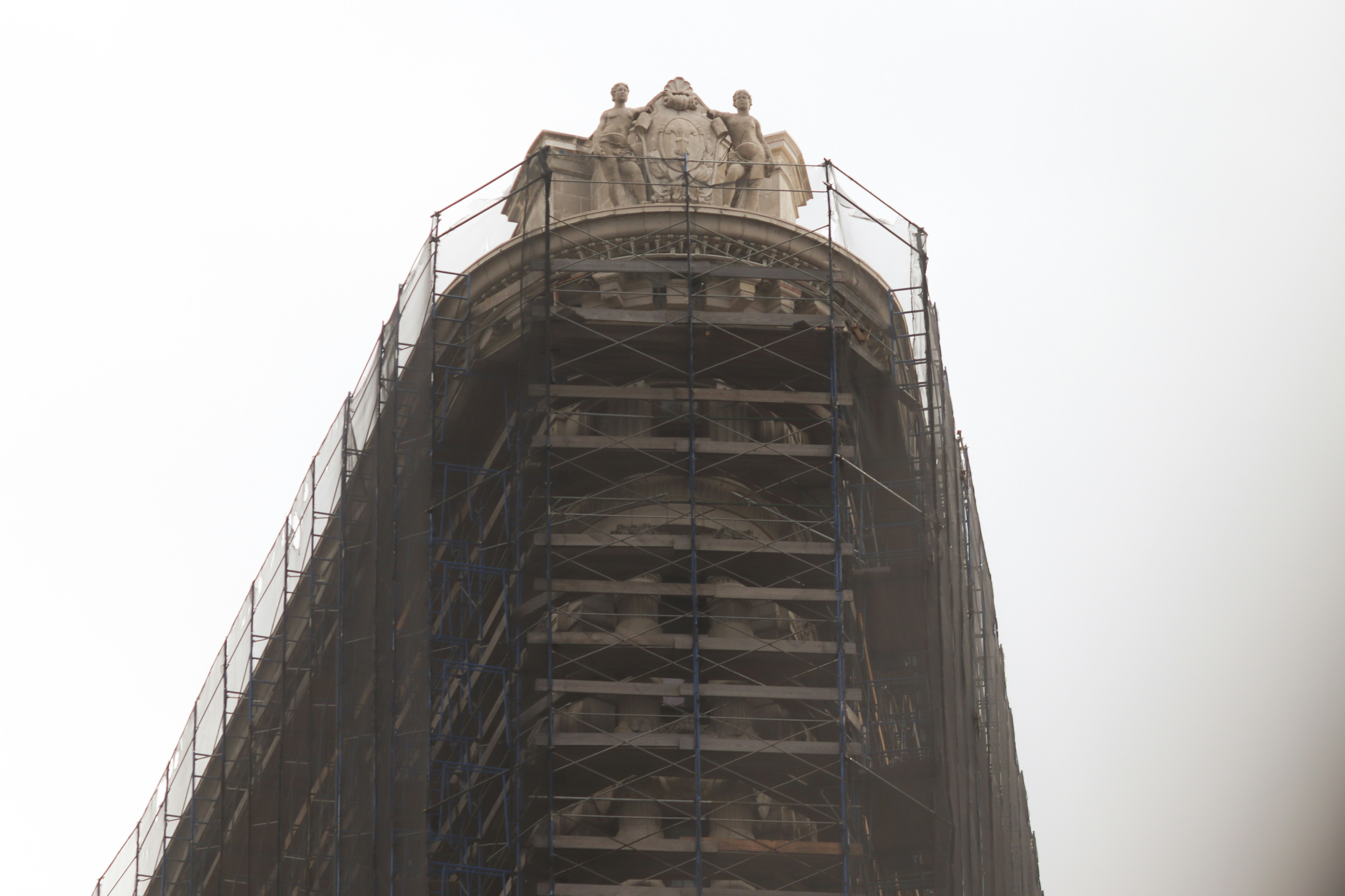 Crowned Summit Enshrouded by Scaffolding in Quiet Fog