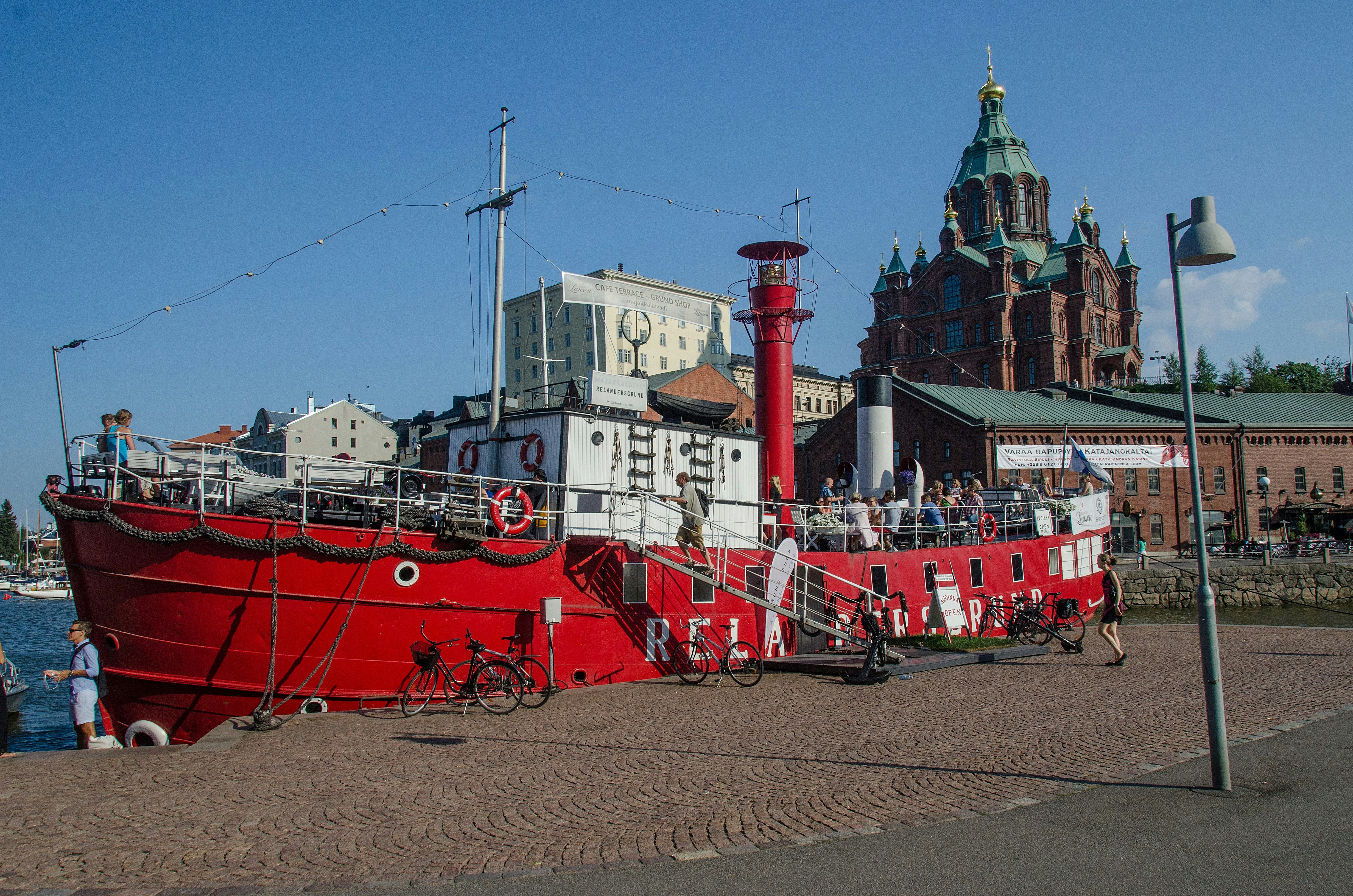 Crimson Vessel at the Quay: Red Ship Framed by a Green-Domed Skyline