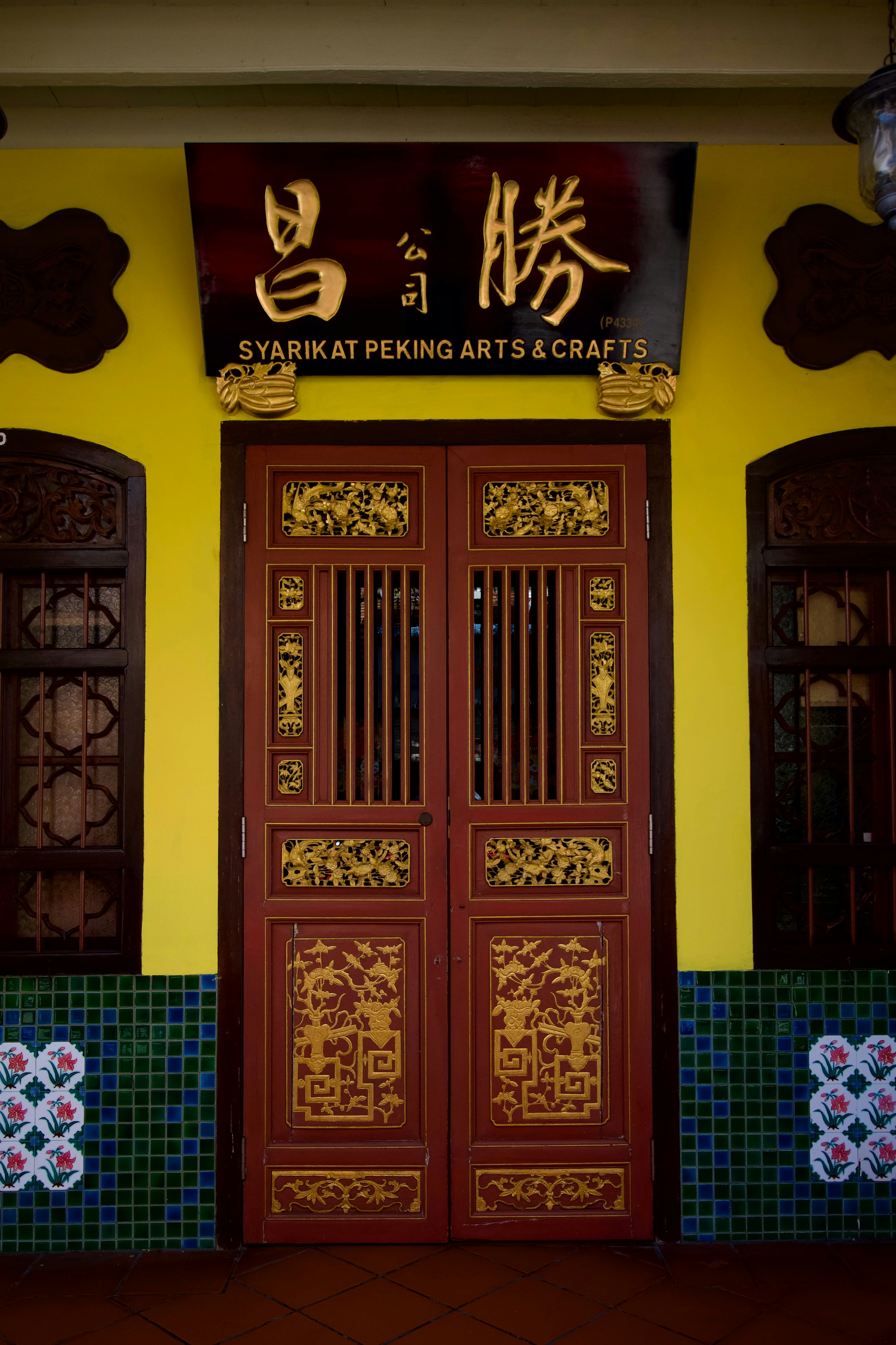 Ornate Red Doors Guard a Yellow Facade—A Peking Arts & Crafts Shopfront