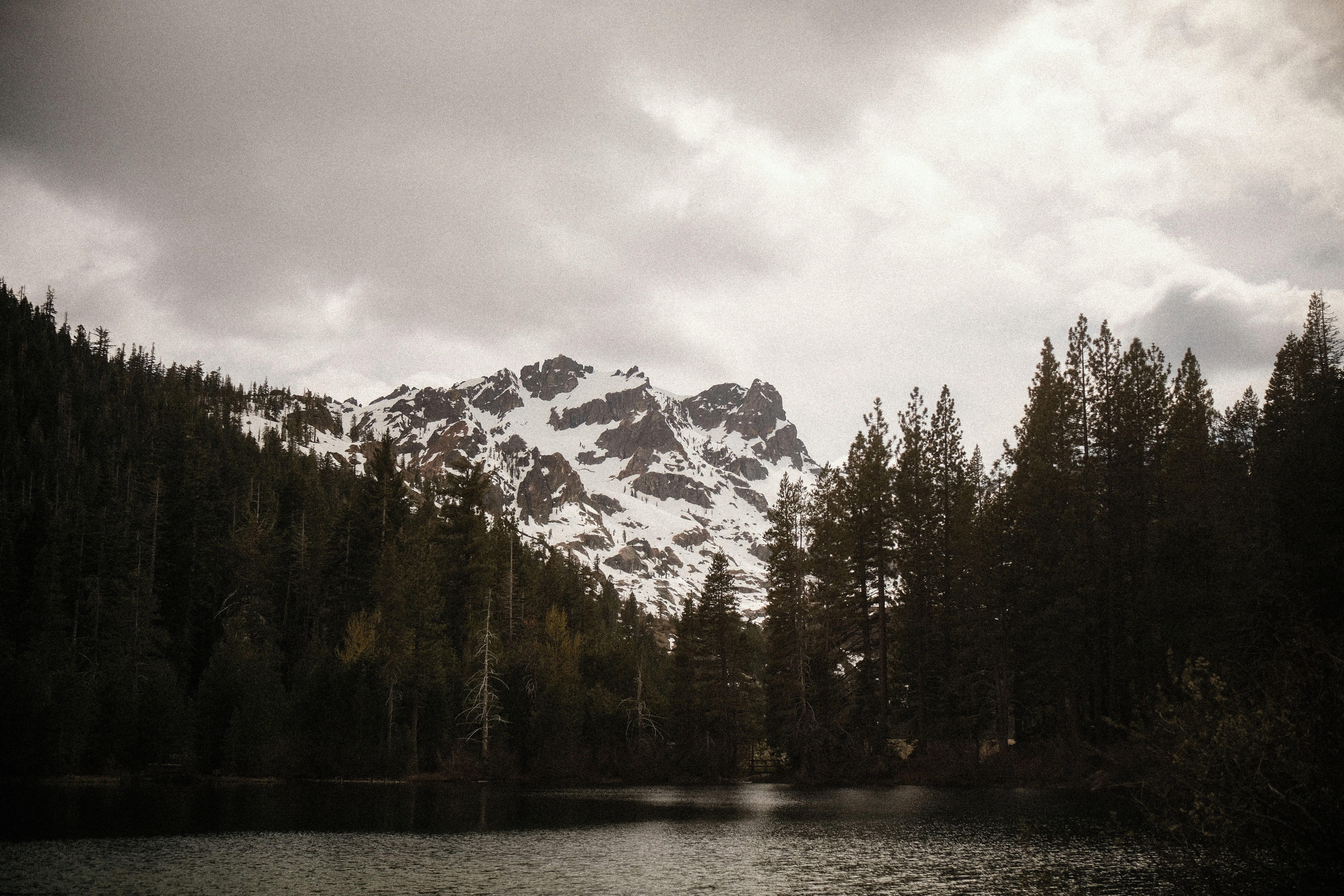 Snowbound Summit Framed by Pines over a Quiet Alpine Lake