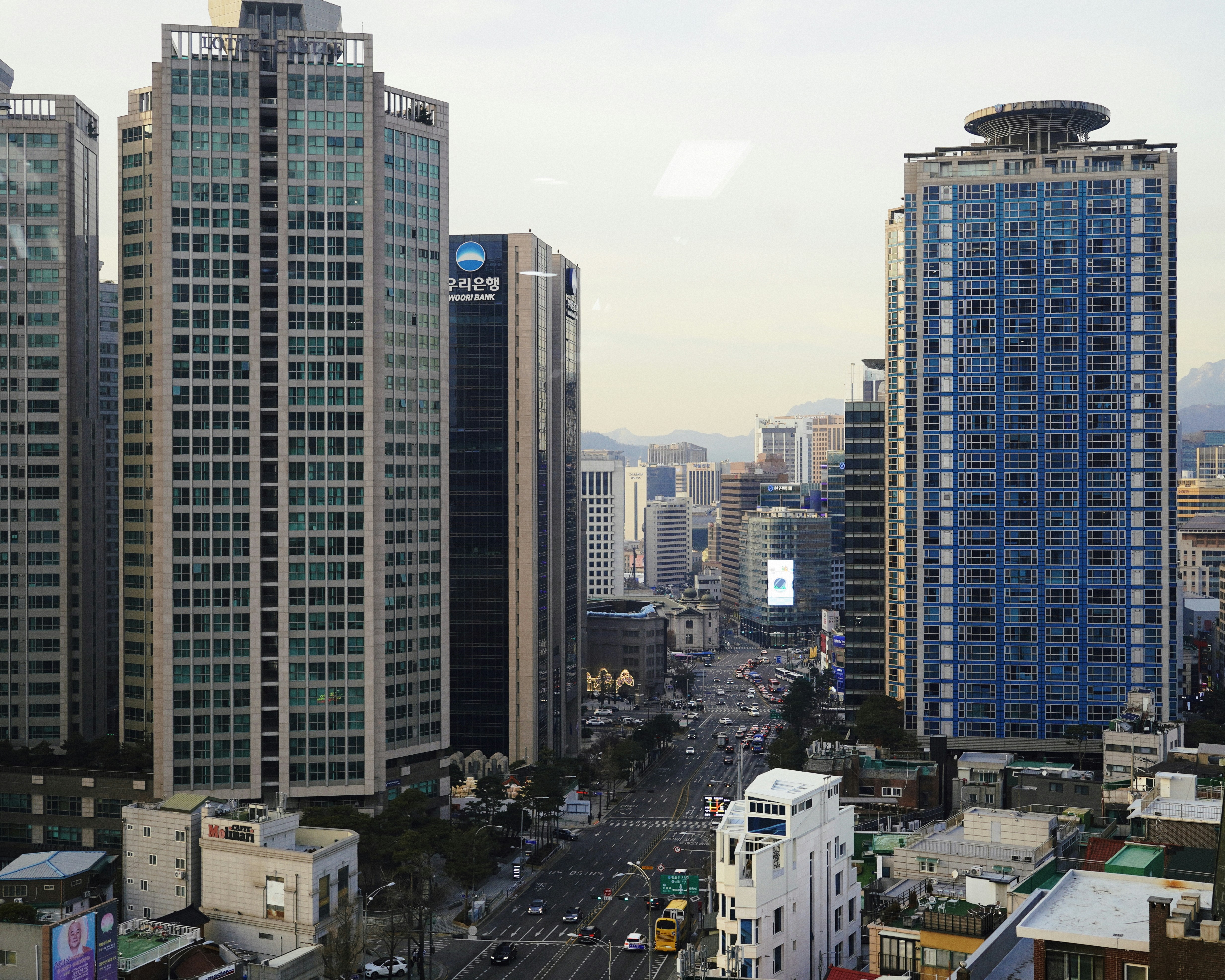 A bustling urban scene showcasing the intricate architecture of skyscrapers against a soft evening sky, highlighting the dynamic energy of city life.