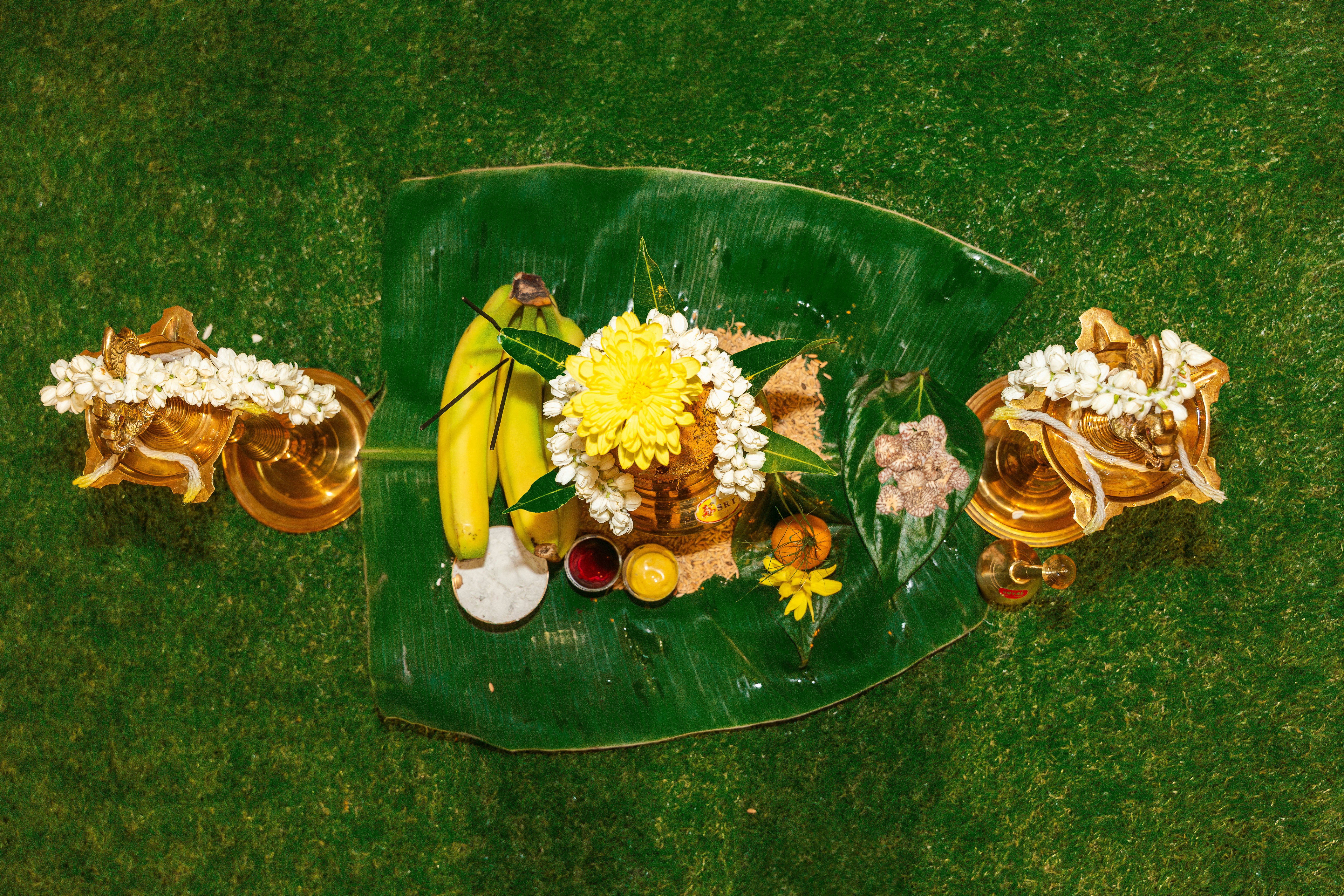 Banana Leaf Altar: Central Floral Centerpiece Framed by Gold Accents on Grass