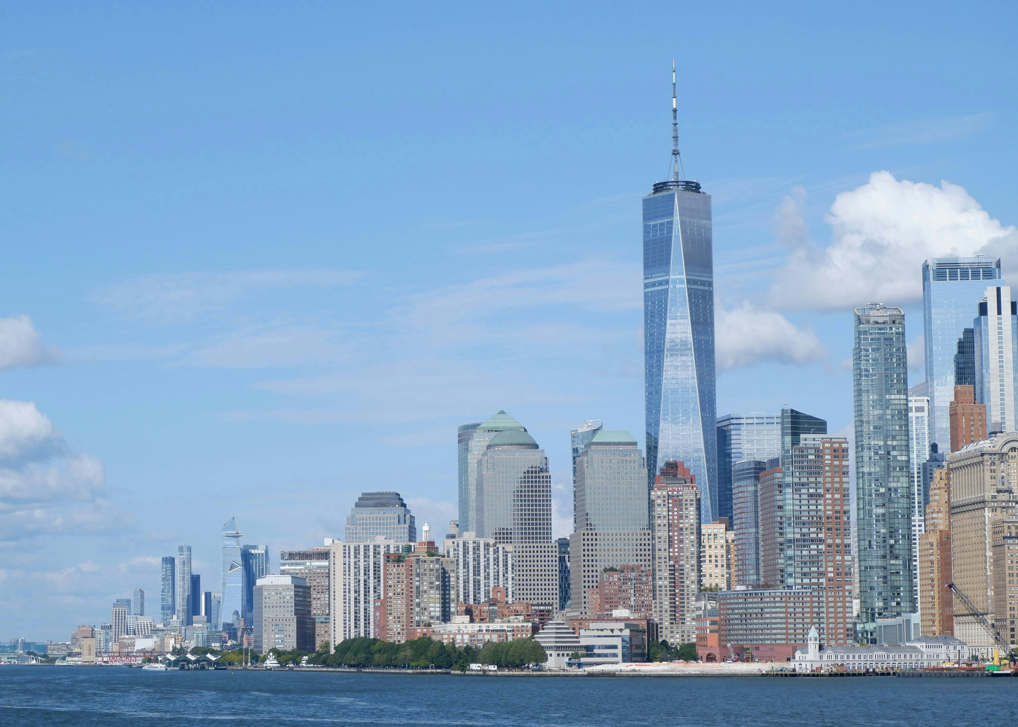 The new york city skyline towers over the water. photo – Free New york Image on Unsplash