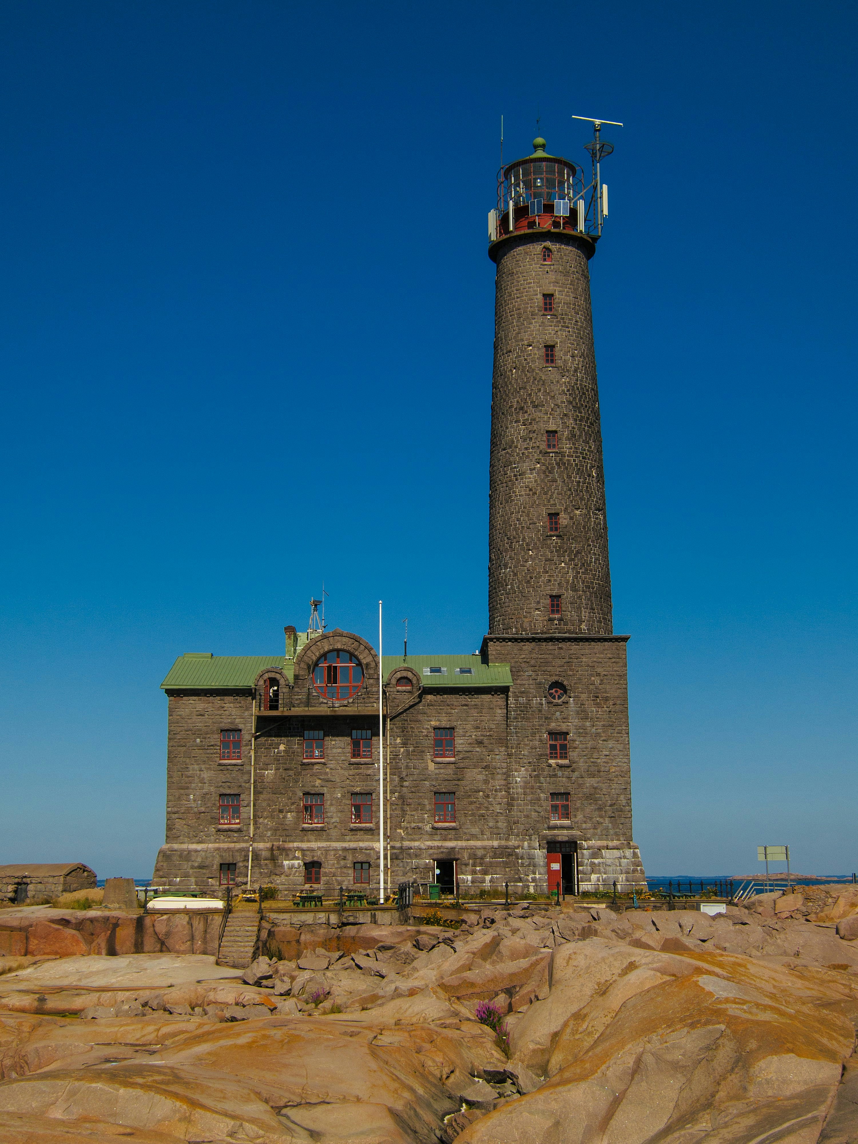A tall lighthouse stands against a bright blue sky. photo – Free ...