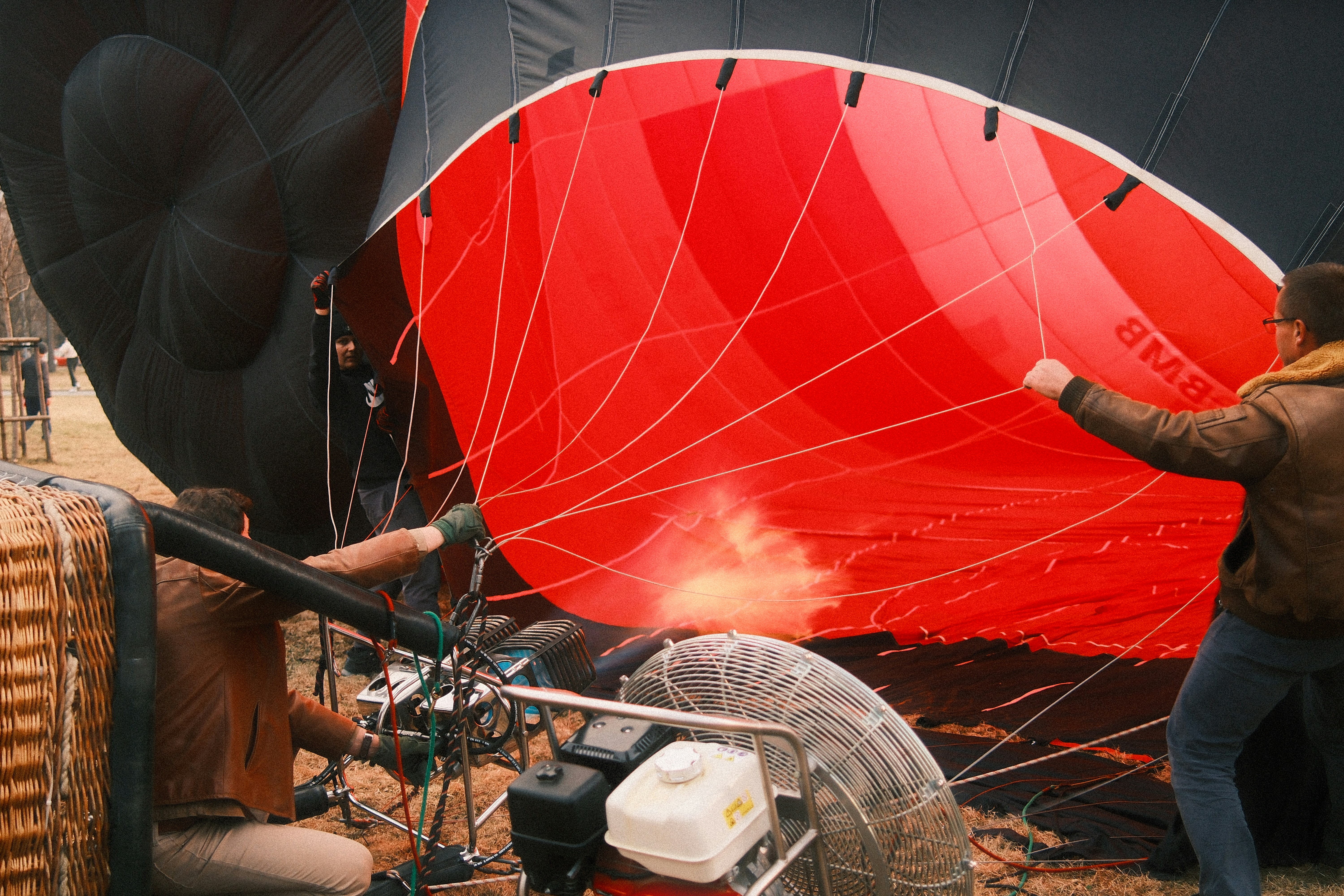 Crimson Lift: Ground Crew Orchestrates a Balloon Inflate