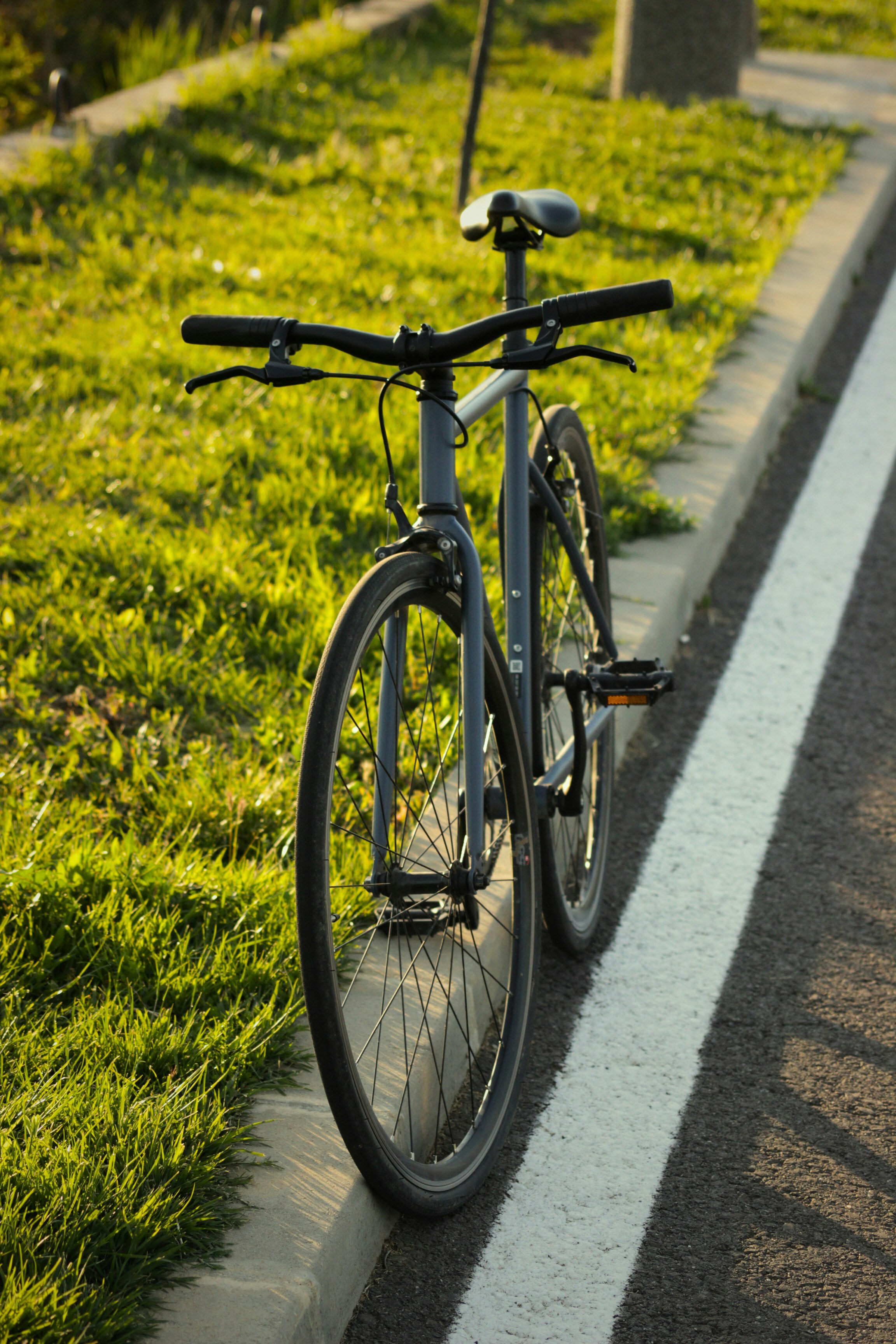 A bicycle rests beside a road. photo – Free Vehicle Image on Unsplash