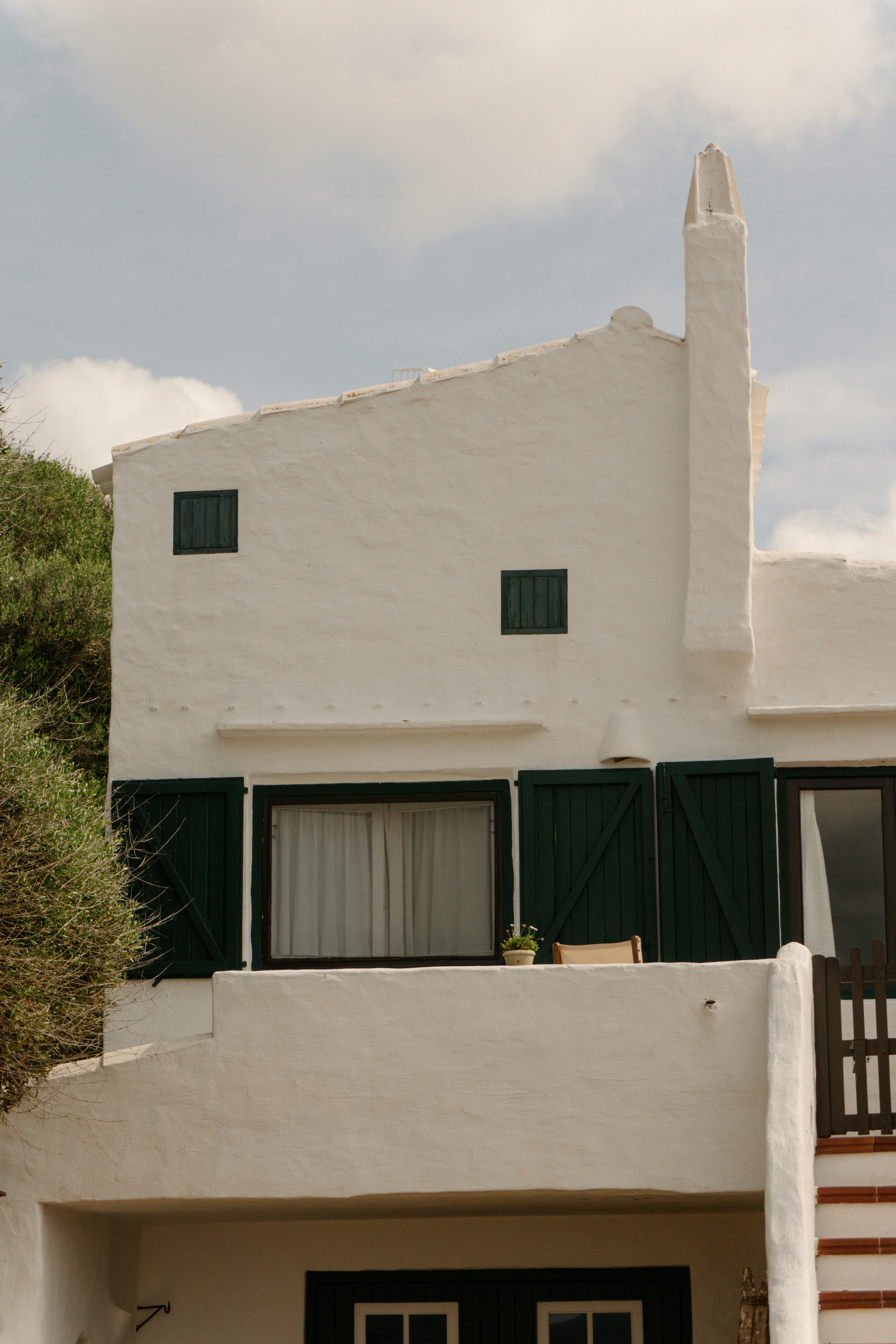 Sunlit White Villa with Green Shutters and a Quiet Balcony