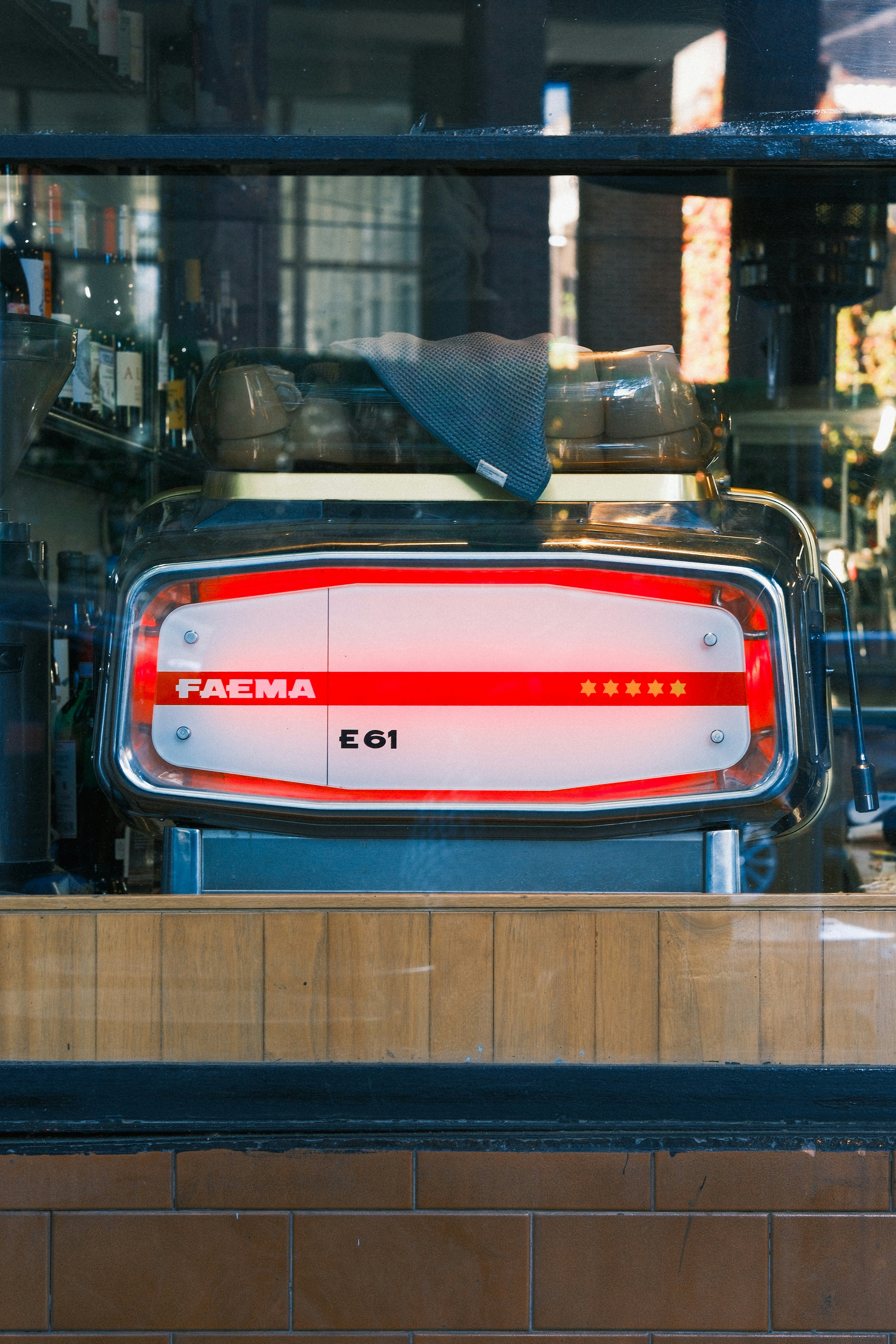 E61 in Glass: A Vintage Espresso Machine Framed by Shopfront Reflections